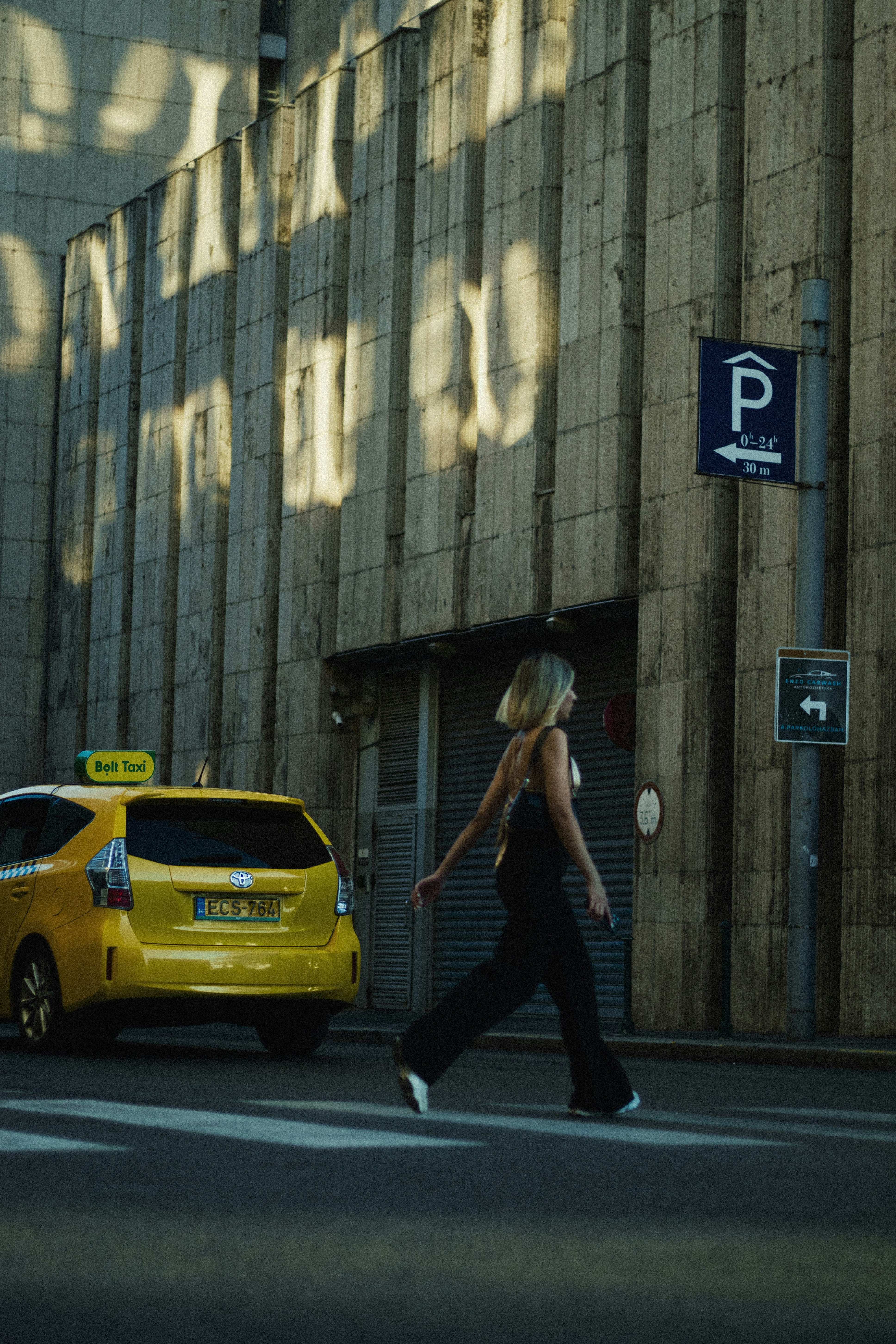 City Walk: The Blonde Traveler Crosses the Shadowed Façade