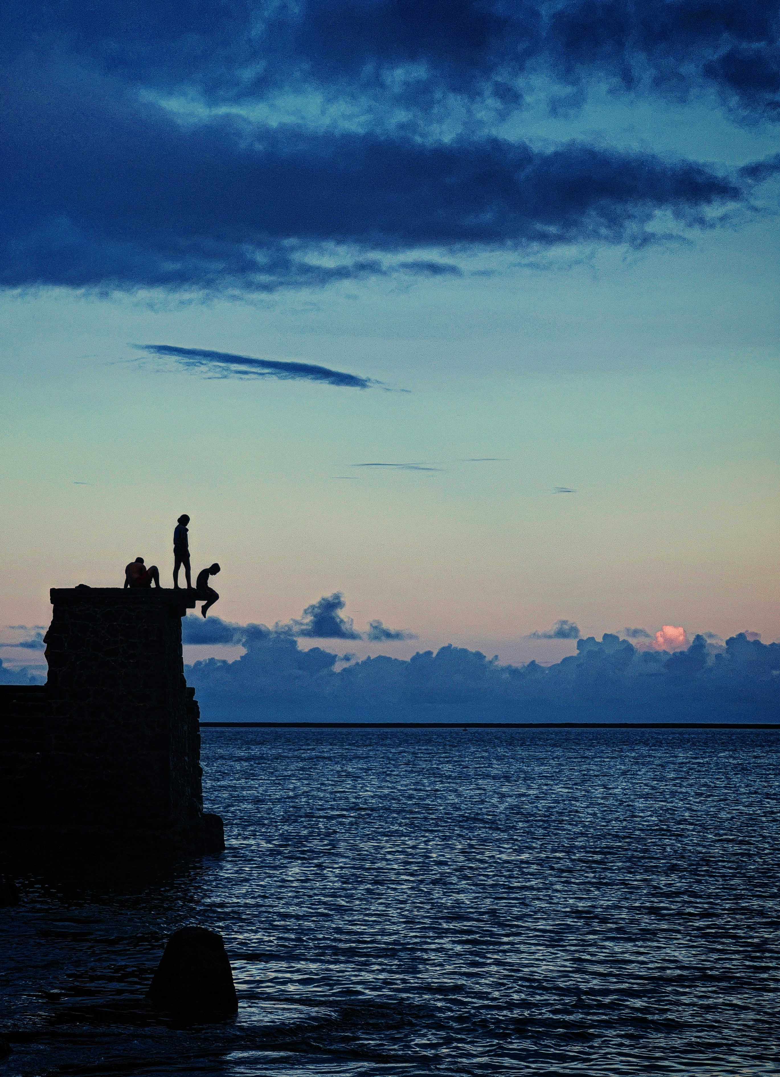 Silhouetted Figures on a Sea Cliff at Dusk