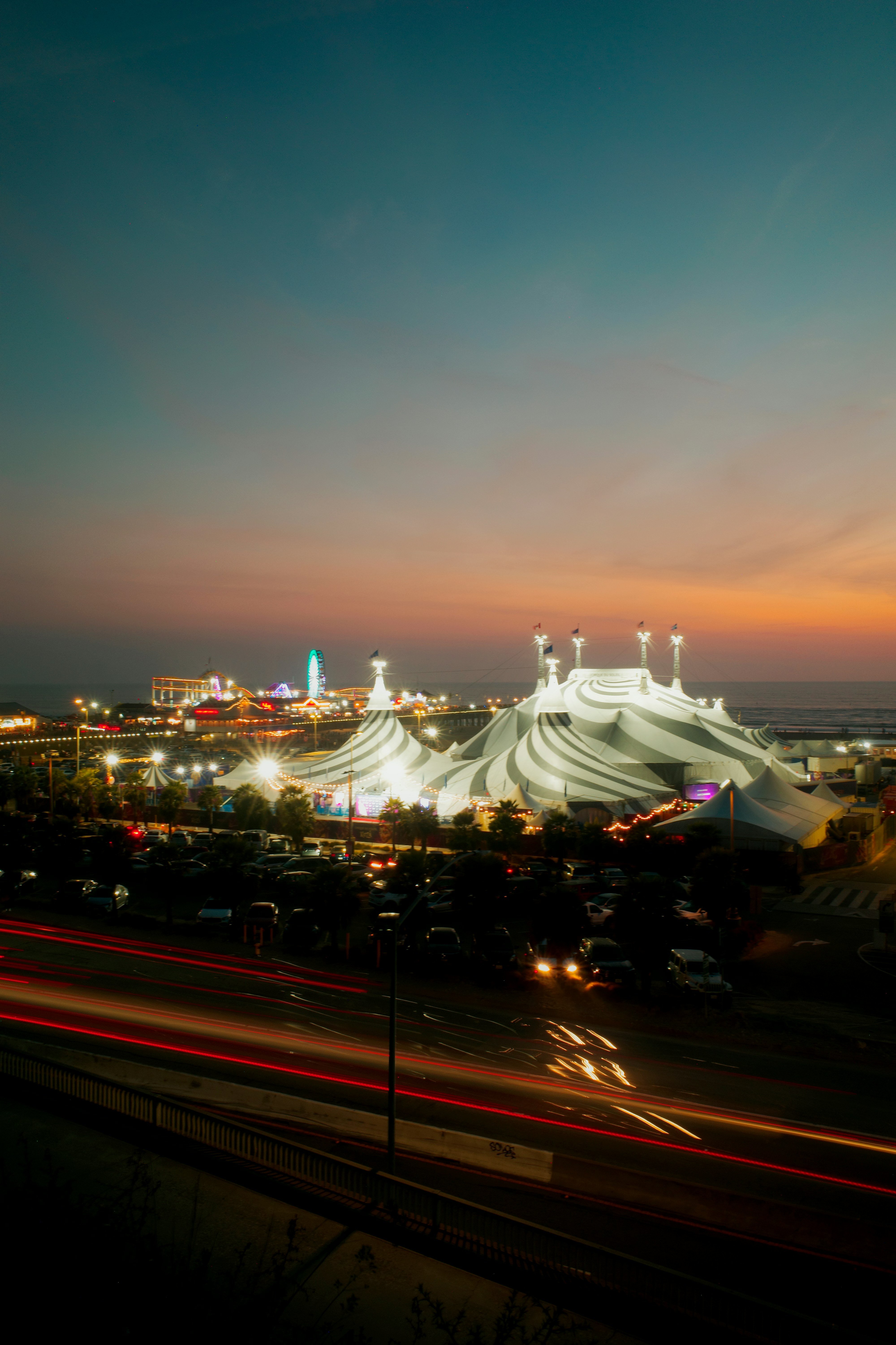 Luminous Tents by the Sea: Evening Spectacle Under a Coral Sky