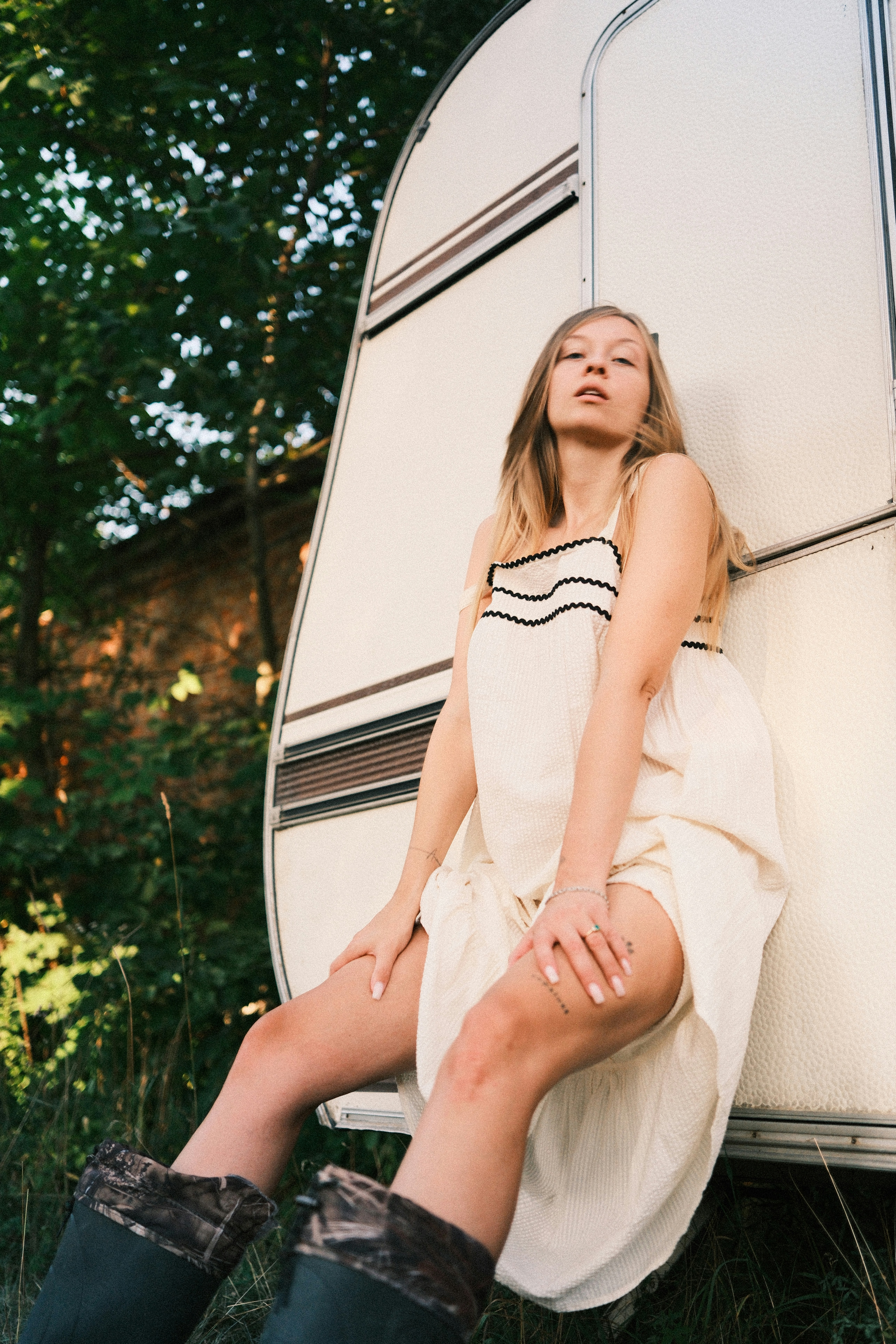 Portrait by the Caravan: A sunlit moment beside a vintage trailer