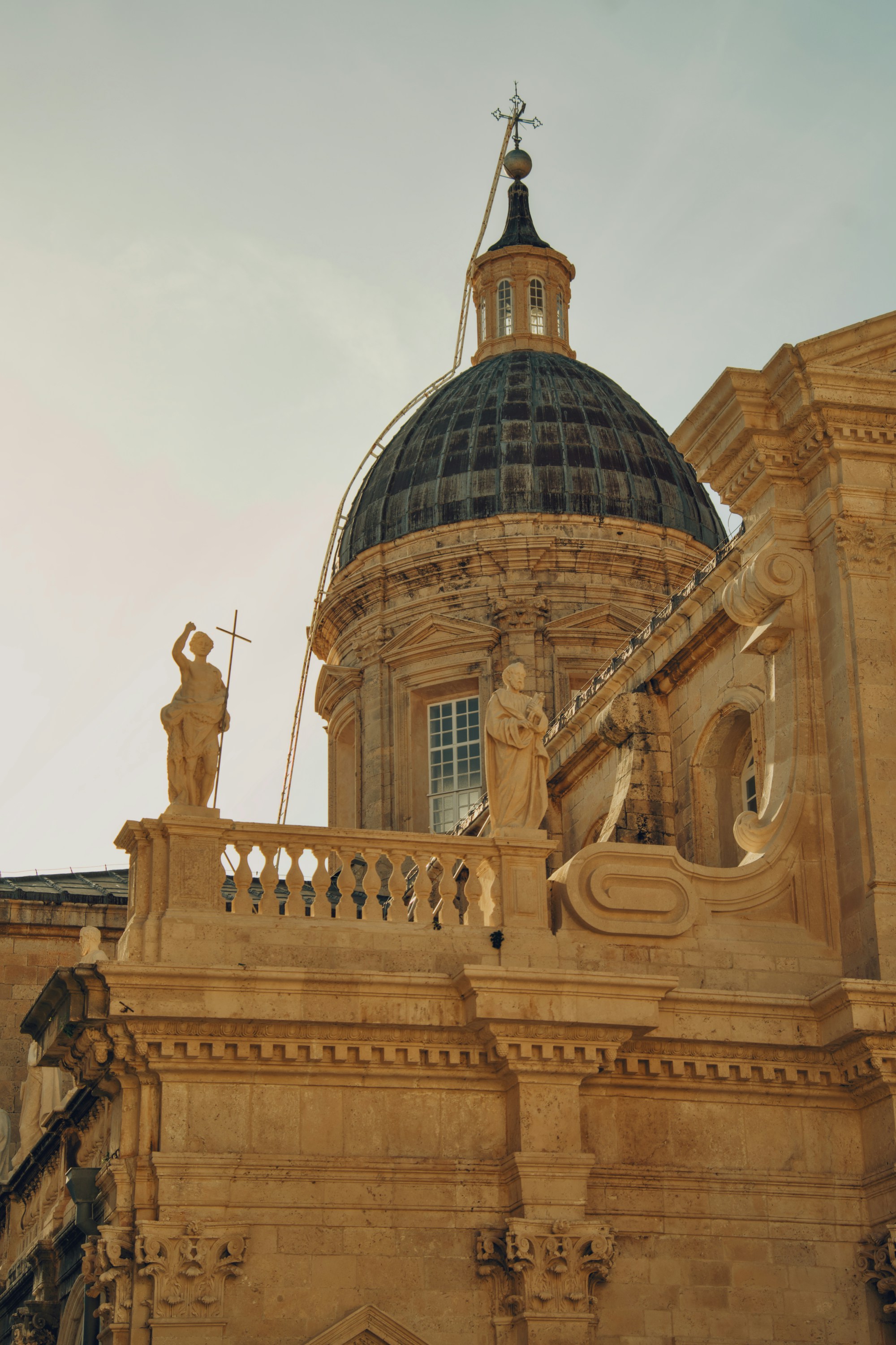 Dome and statues at sunlit historic facade