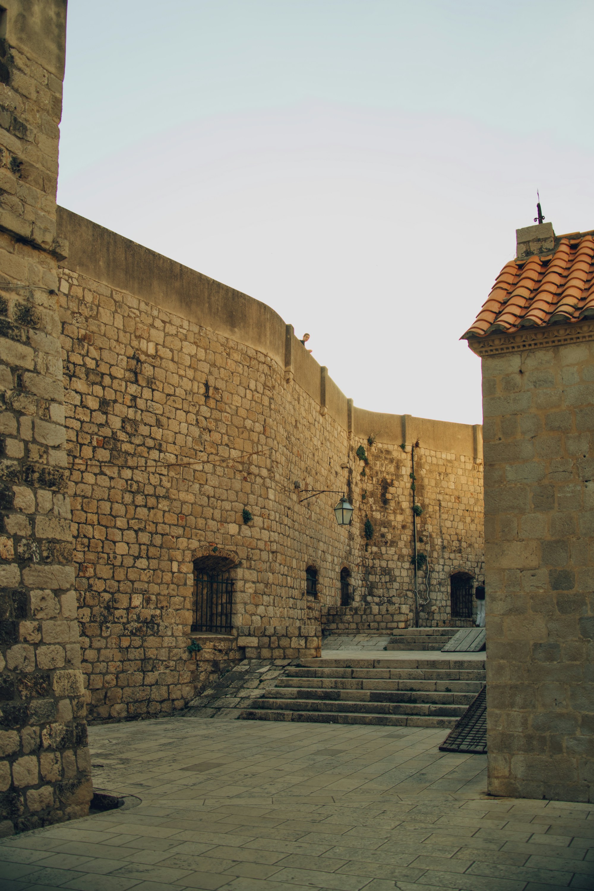 Sunlit Medieval Passageway Between Stony Walls