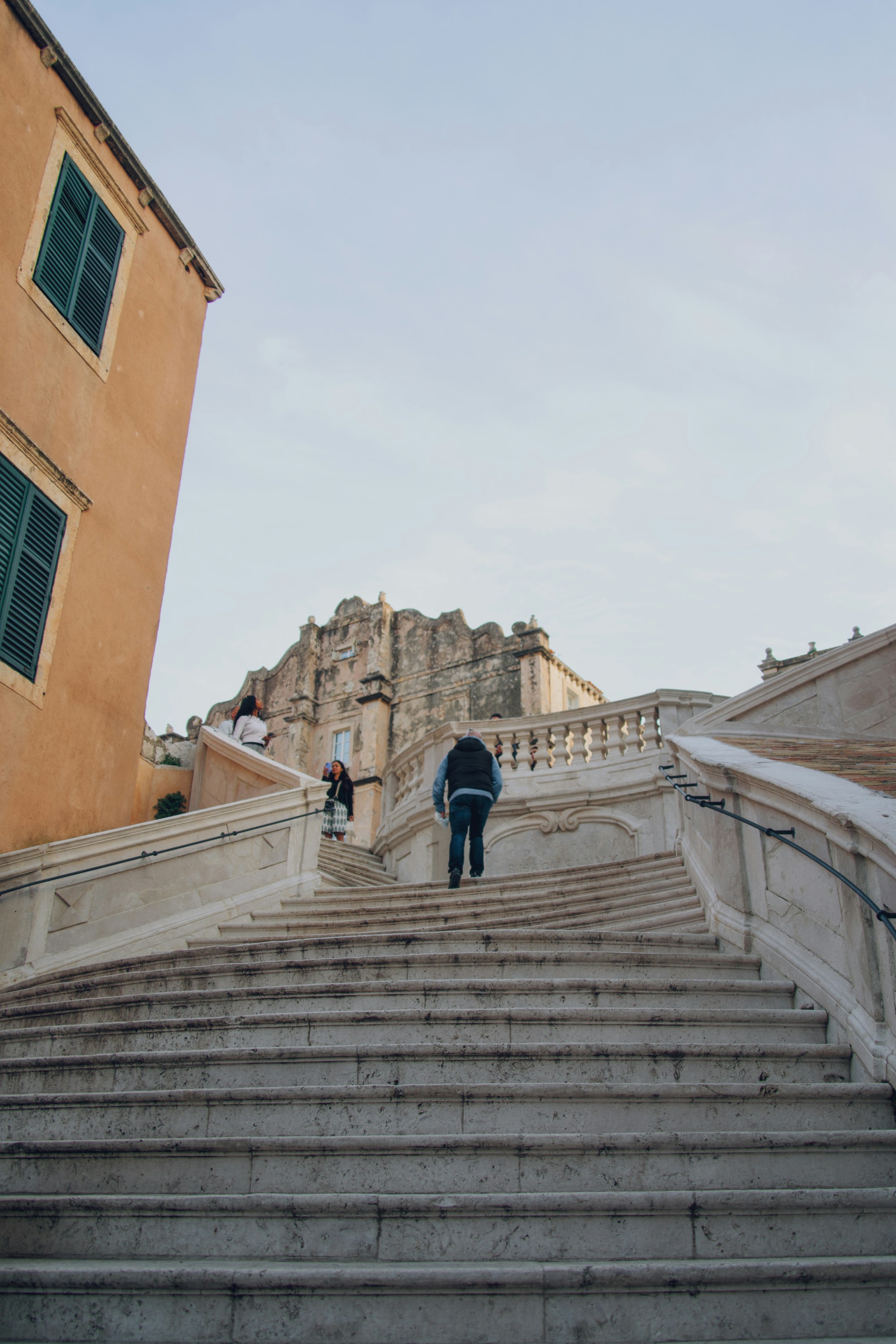Upward Ascent: Travelers on a Grand Marble Staircase