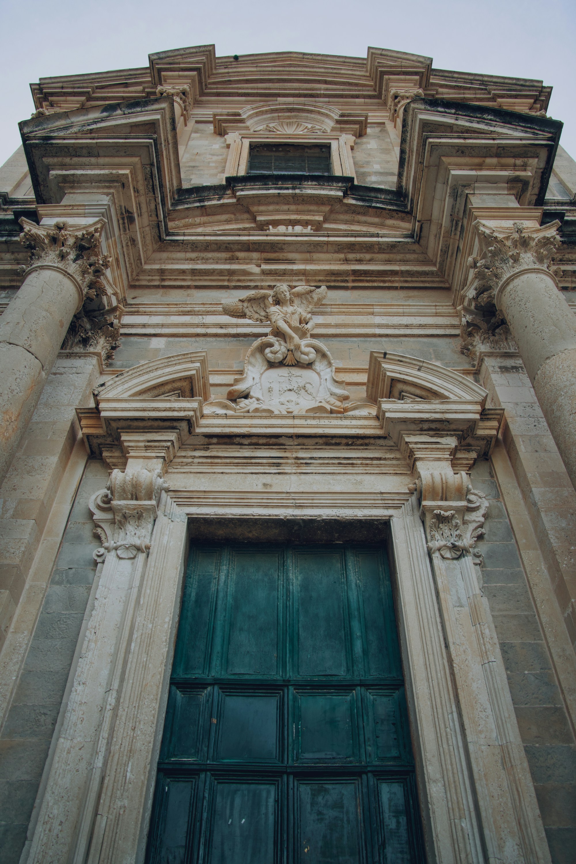 Baroque Facade Ascending: A Stone Symphony of Columns and Carved Emblems