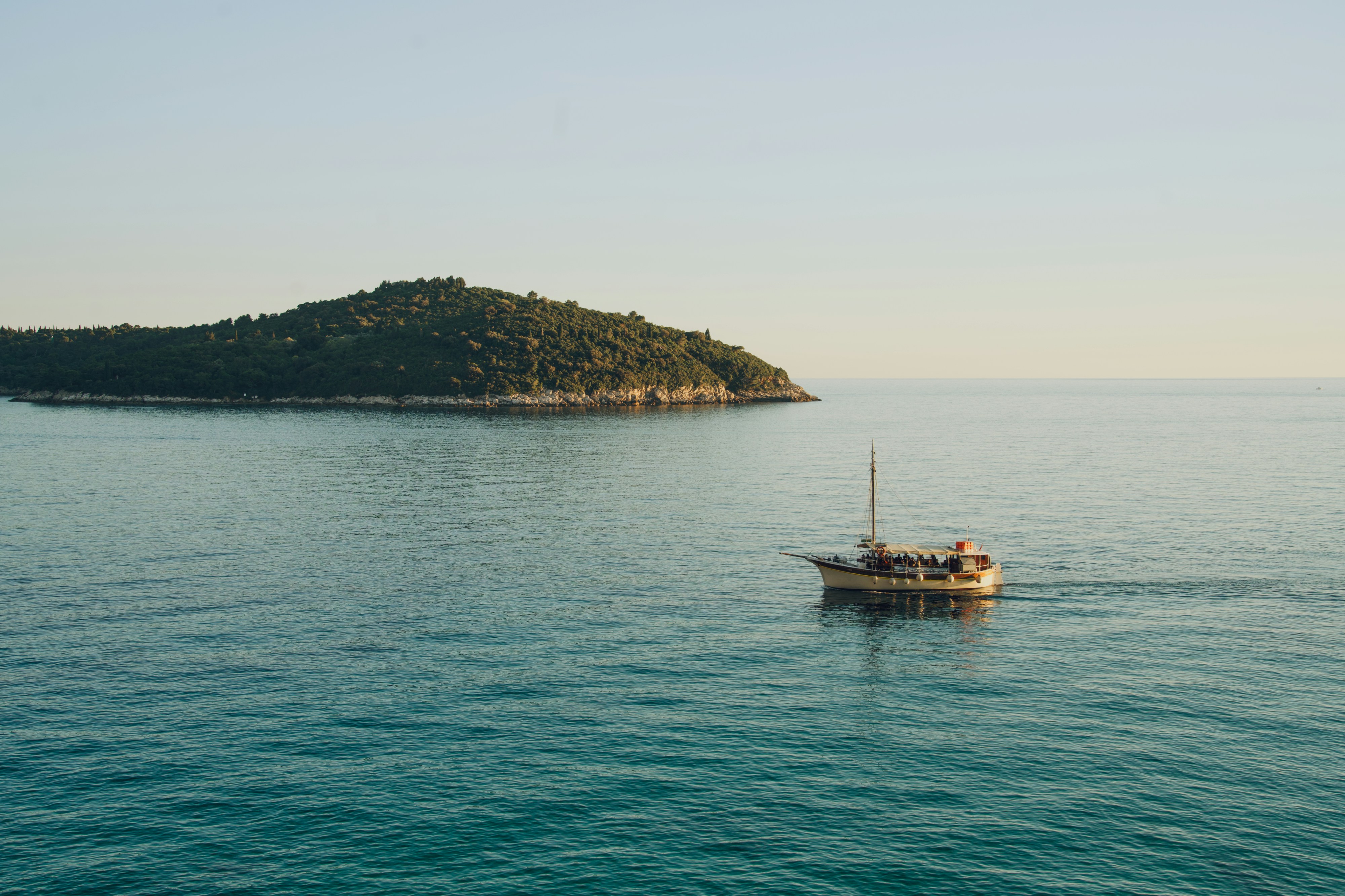 Island outpost: a solitary boat glides toward the quiet horizon