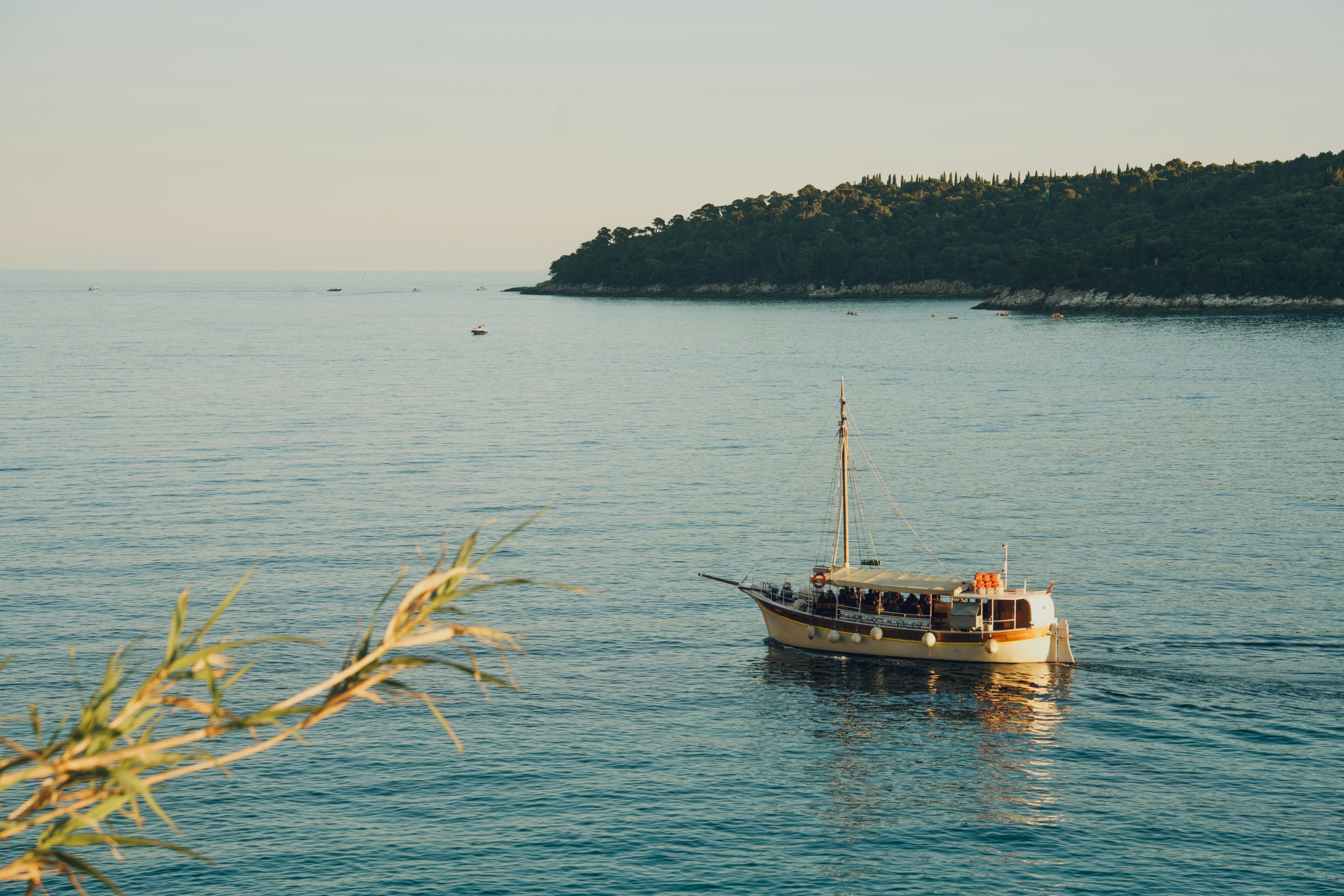Sailing Quiet: A Wharfed Boat Drifts Across Calm Coastal Waters
