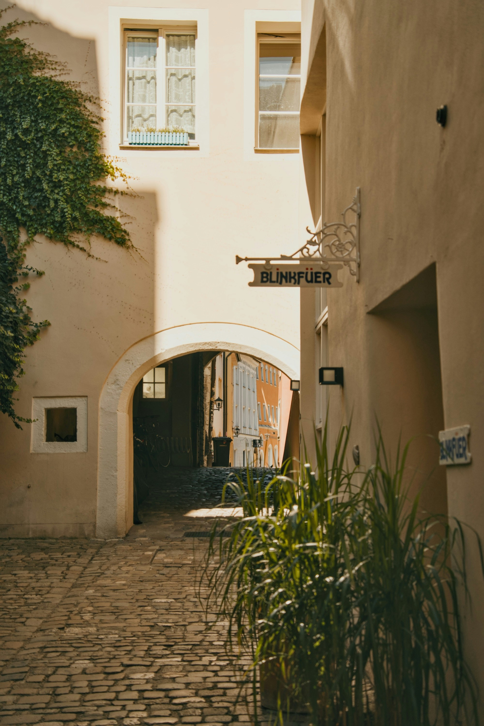 Sunlit Archway Through a Quiet European Alley