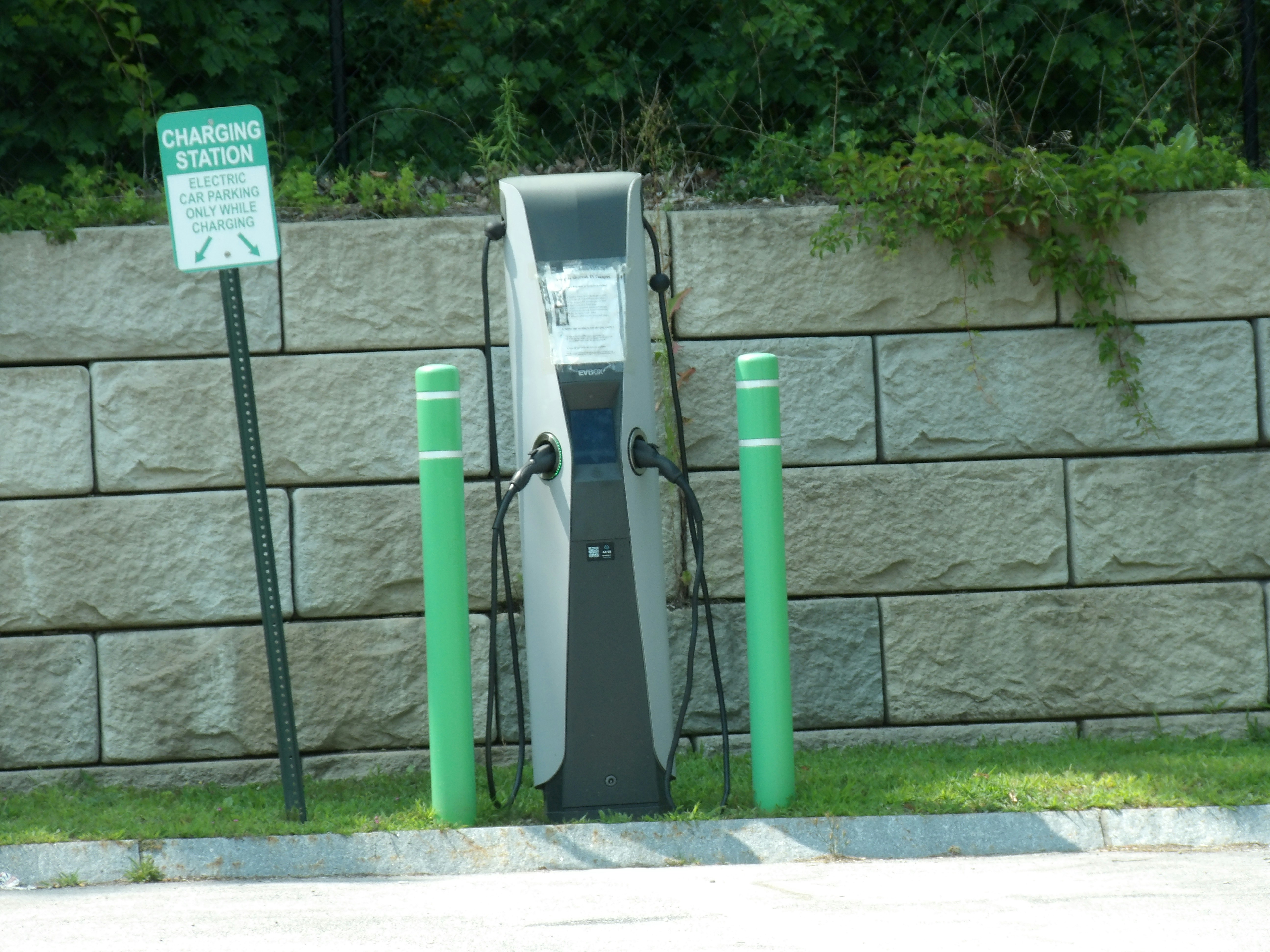 Electric Vehicle Charger Stand Guarded by Green Posts