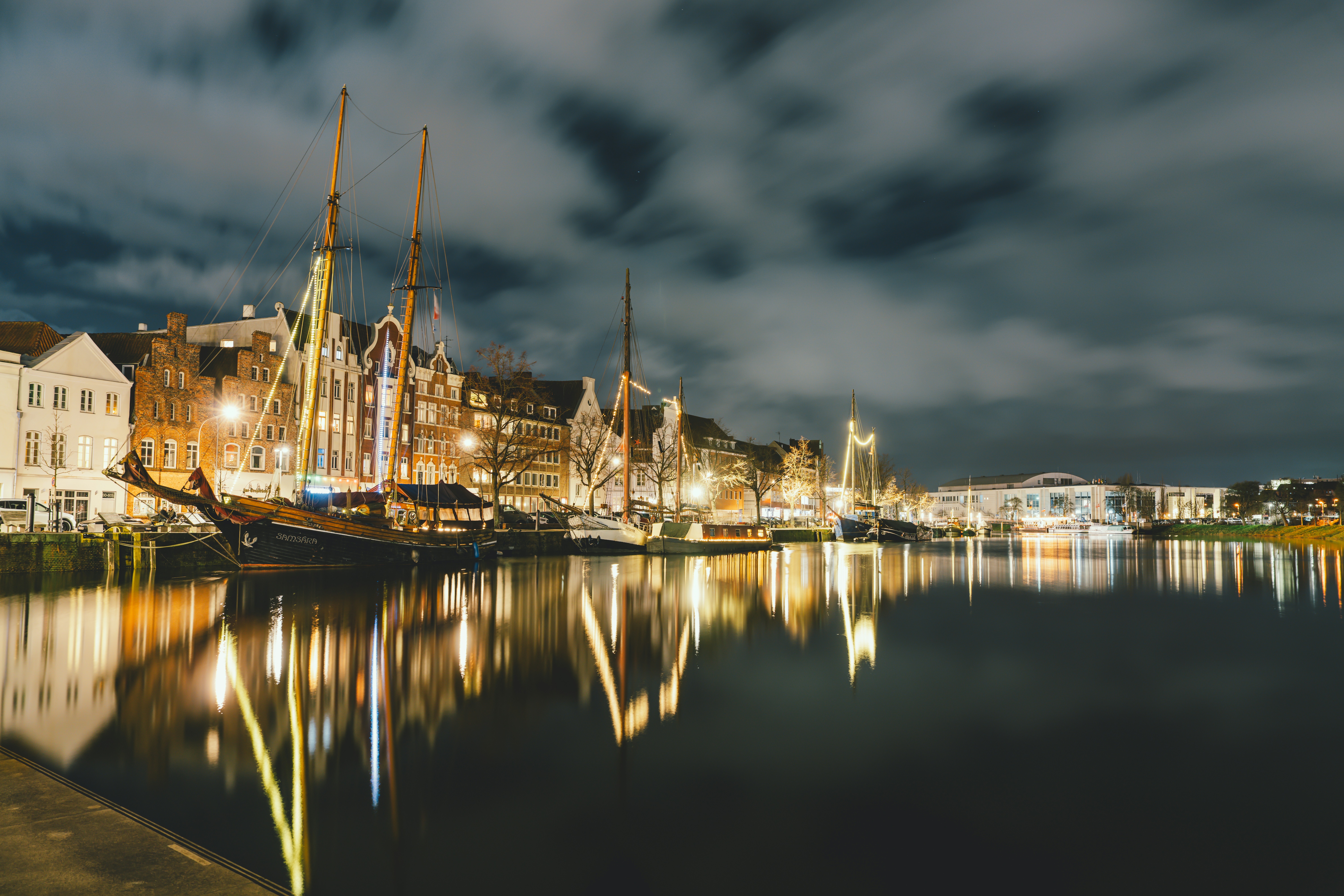 Moonlit Wharf Reflections: Boats and Townscape on a Quiet Harbor
