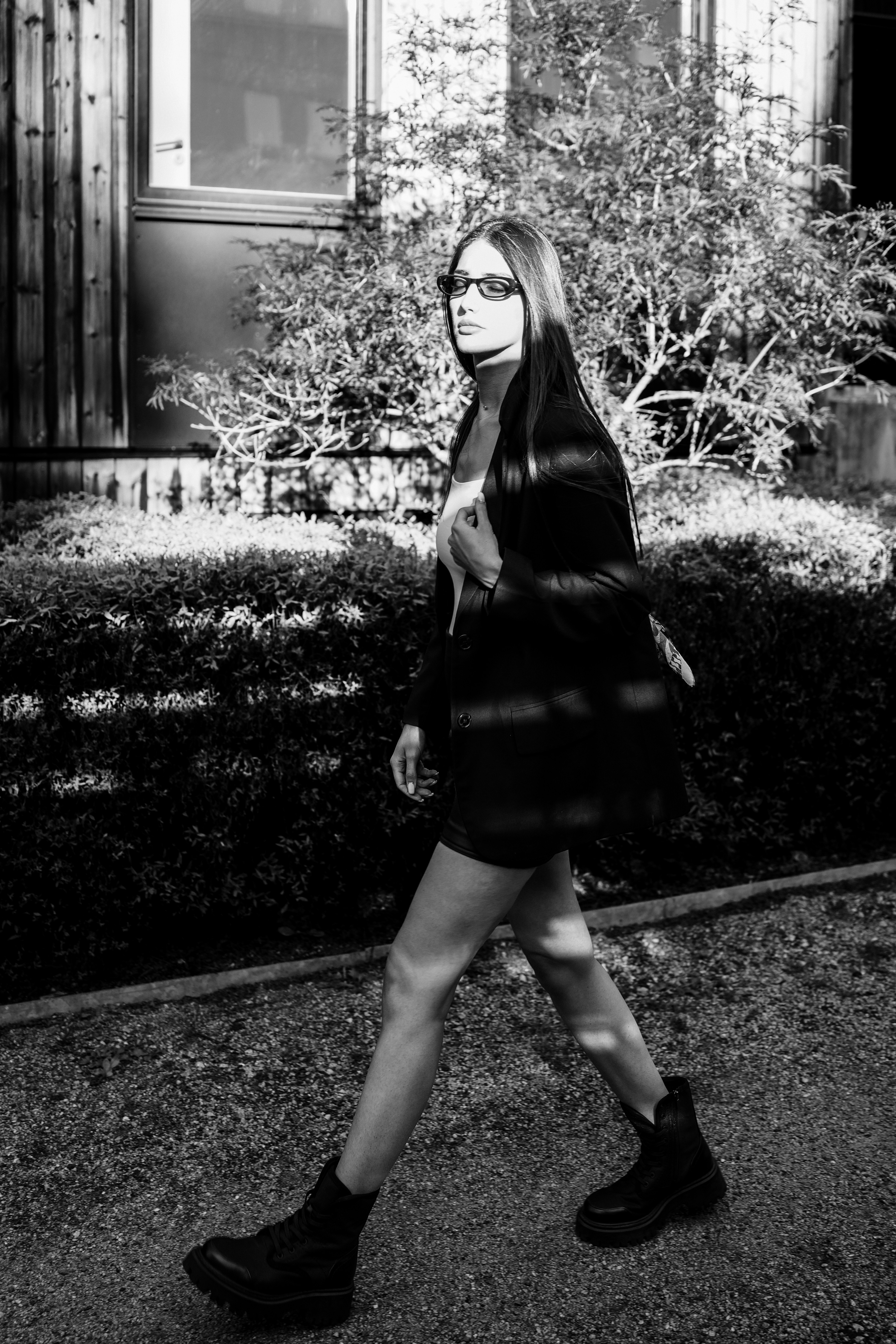 Stride in monochrome: a thoughtful walk past the hedge