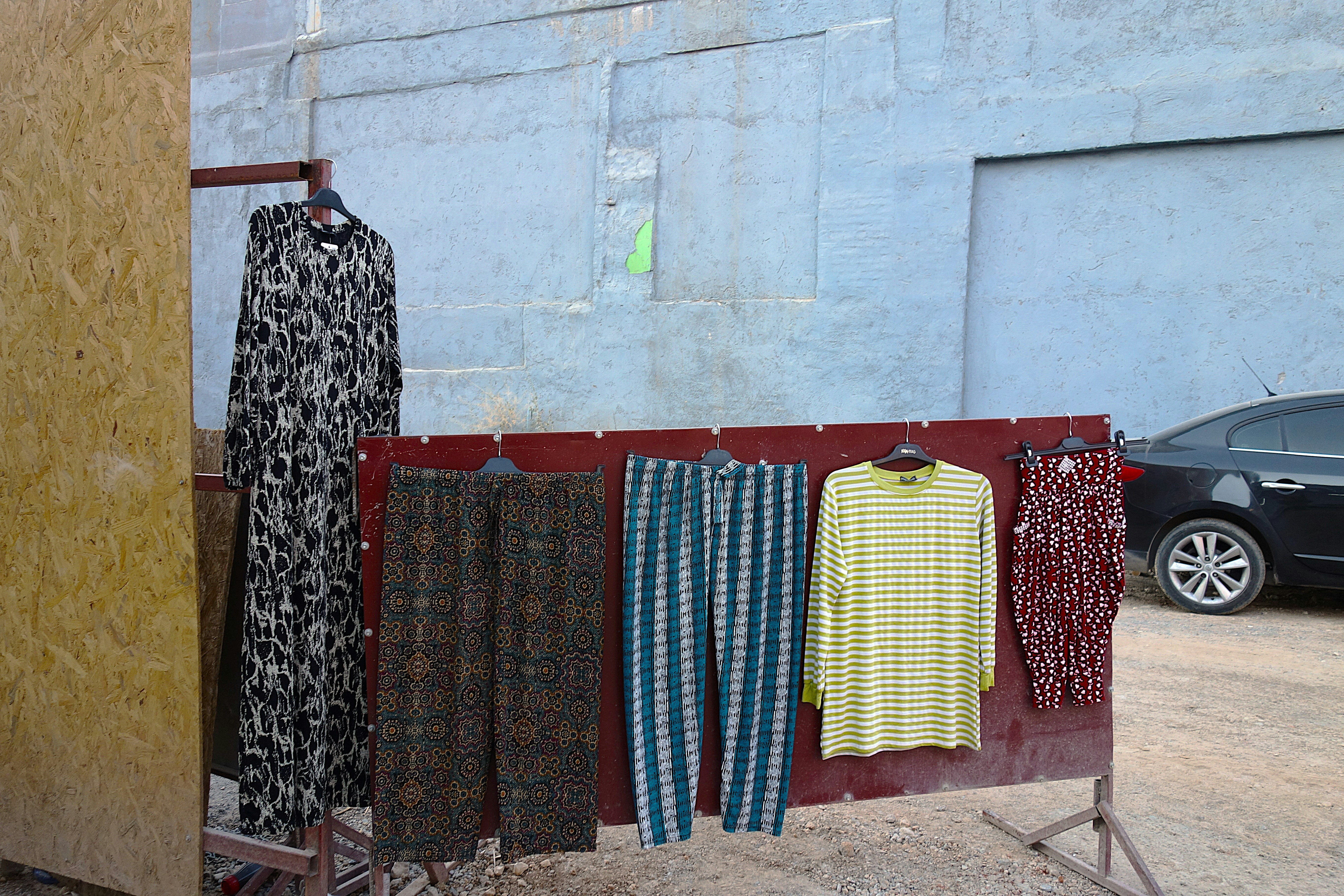 Clothing Stand Under a Weathered Wall