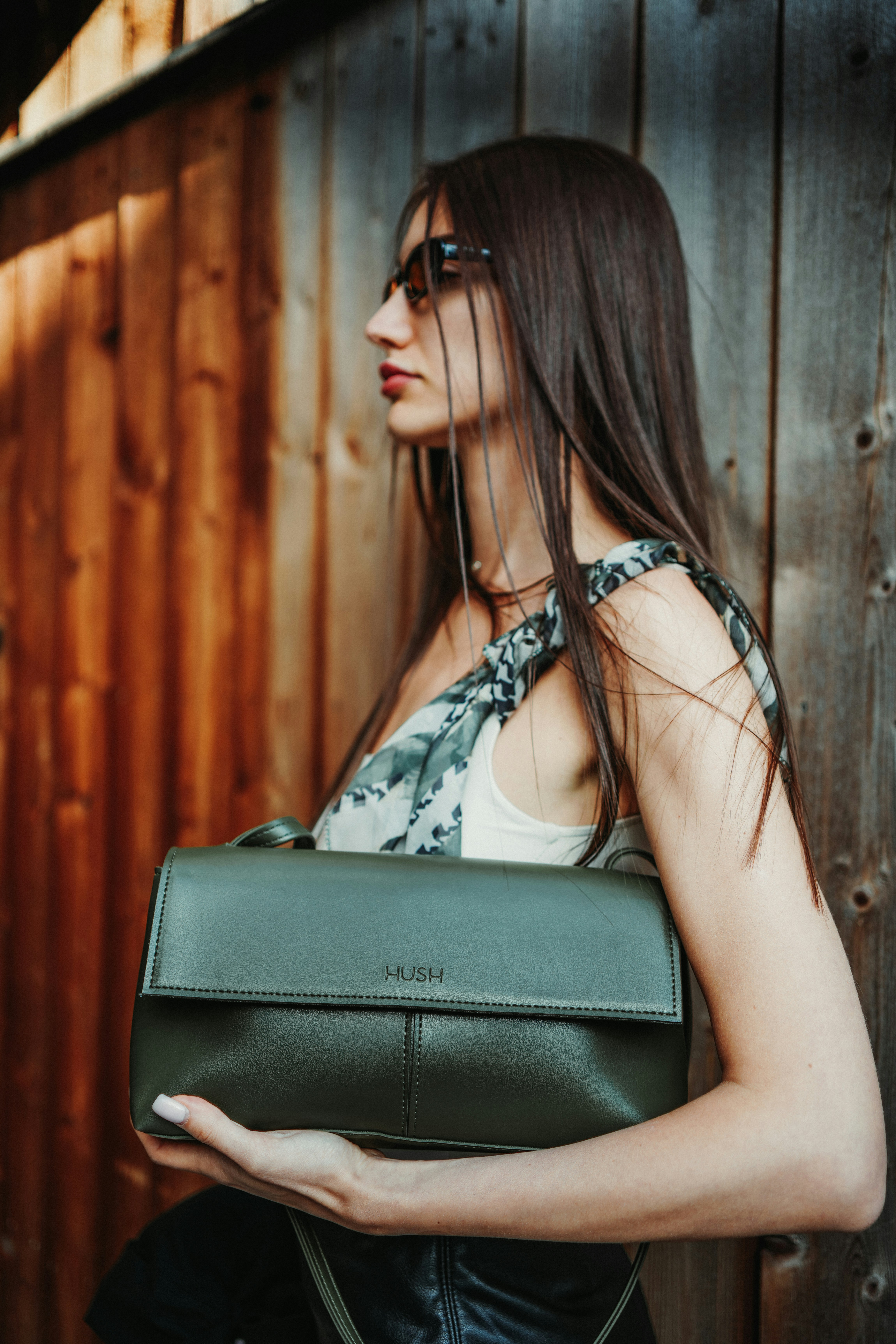 Side Profile with a Green Clutch: Quiet Confidence by the Fence