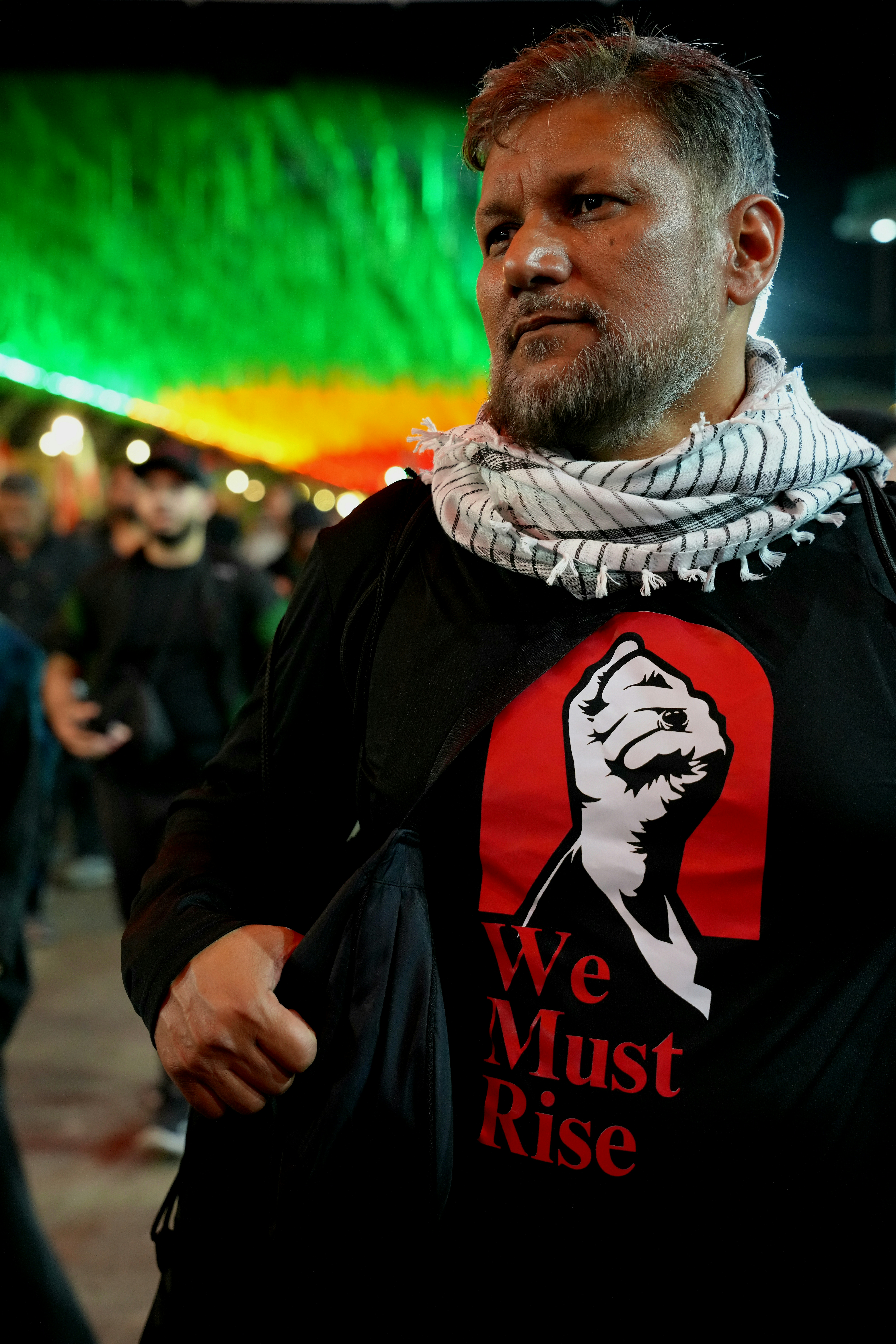 Portrait of Resolve: The Man with a Raised Fist on a Colorful Night