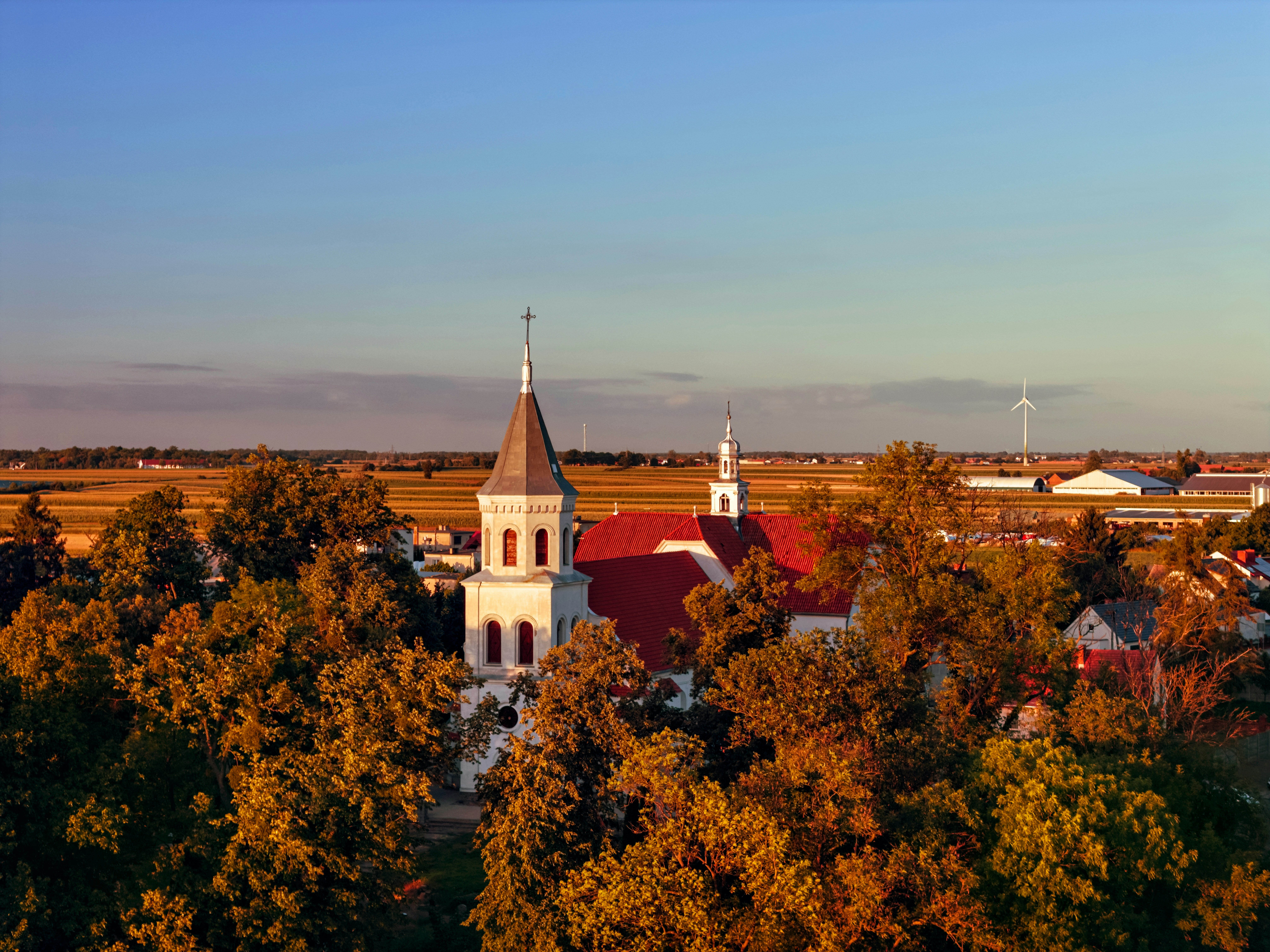 Golden Hour Over a Quiet Town: Church Spires and Wind Turbine