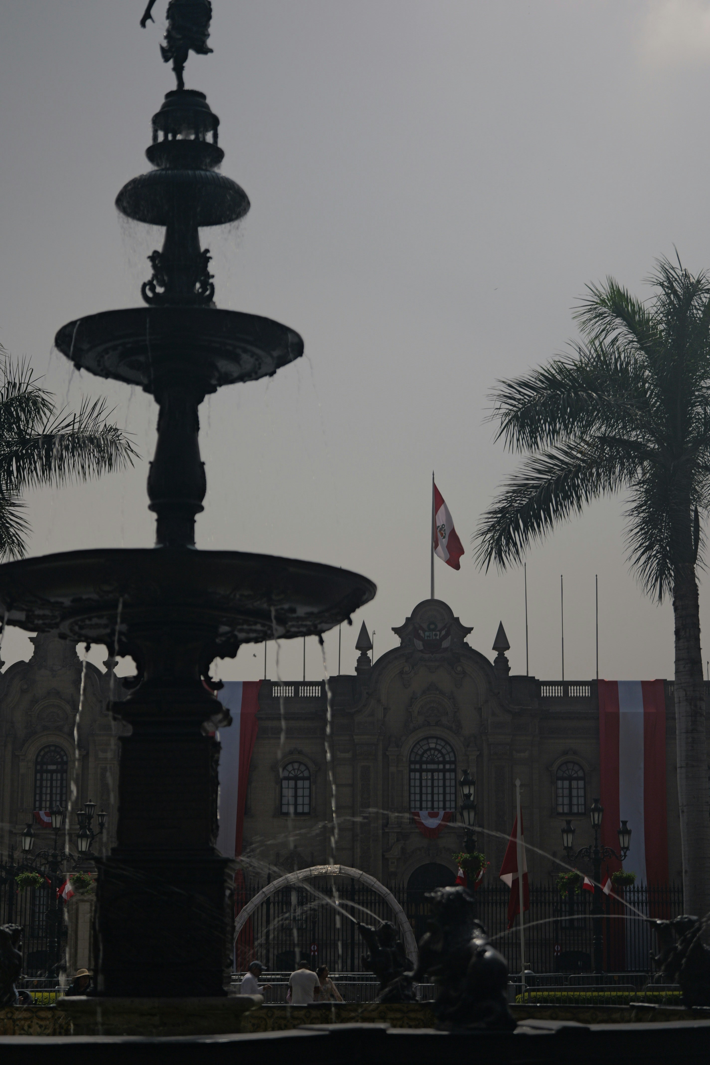 A Quiet Plaza Framed by a Tall Fountain and Statue