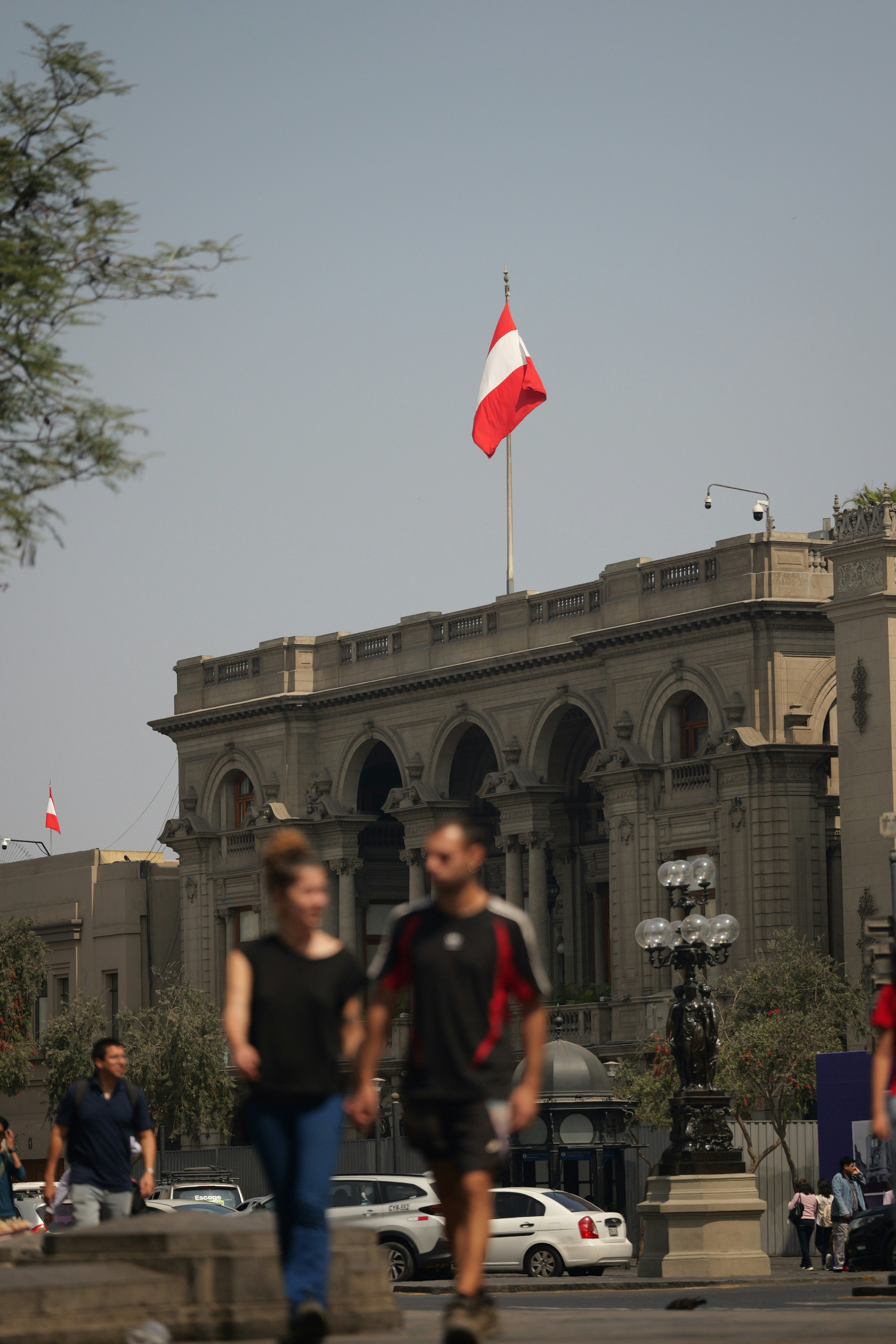 Flag above a grand façade: Central focus on life in a historic square