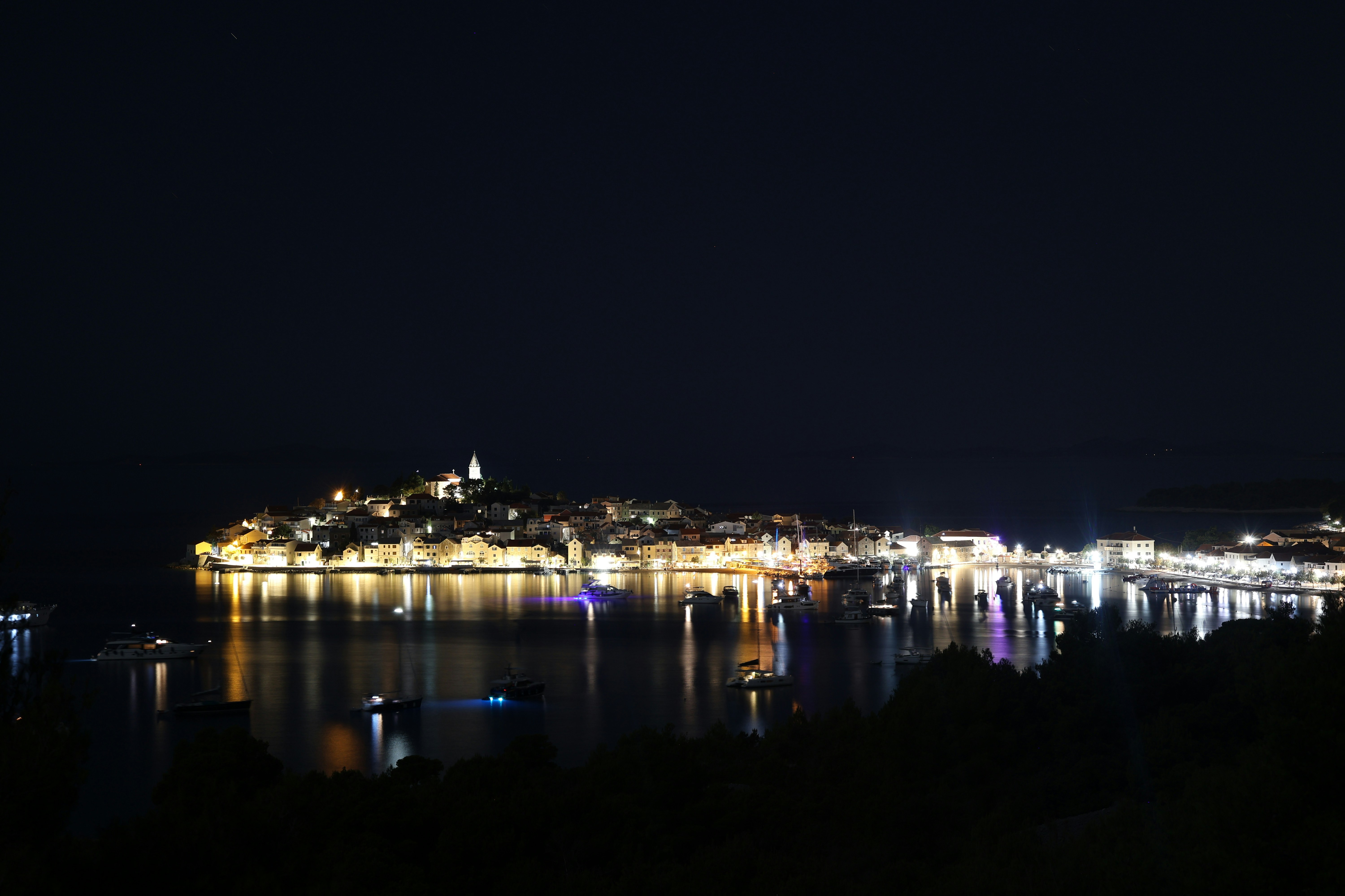 Night Harbor Lights: A Coastal Town Glowing Across Calm Waters