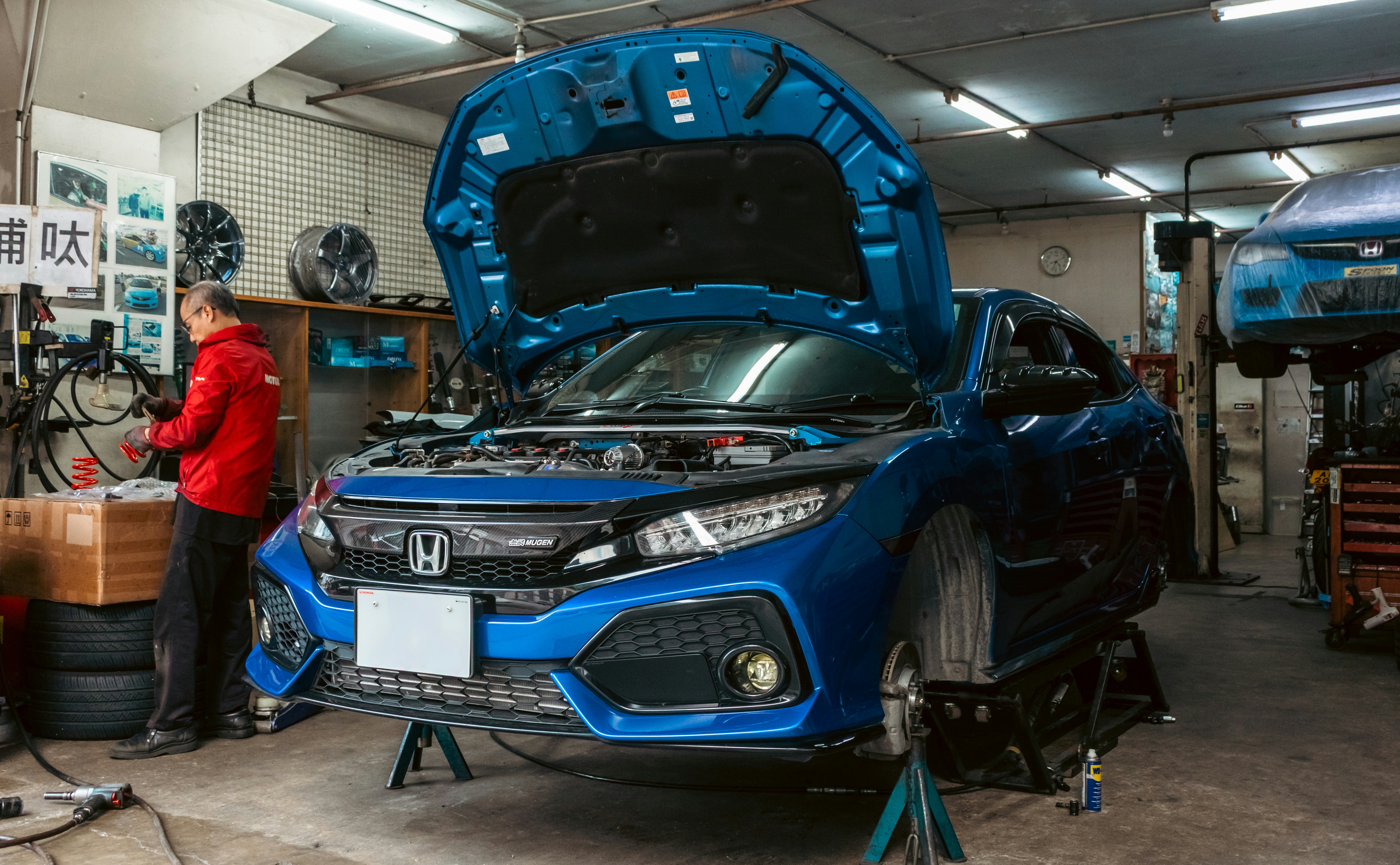 Blue Honda in a Workshop: Open Hood, Ready for a Tune-Up