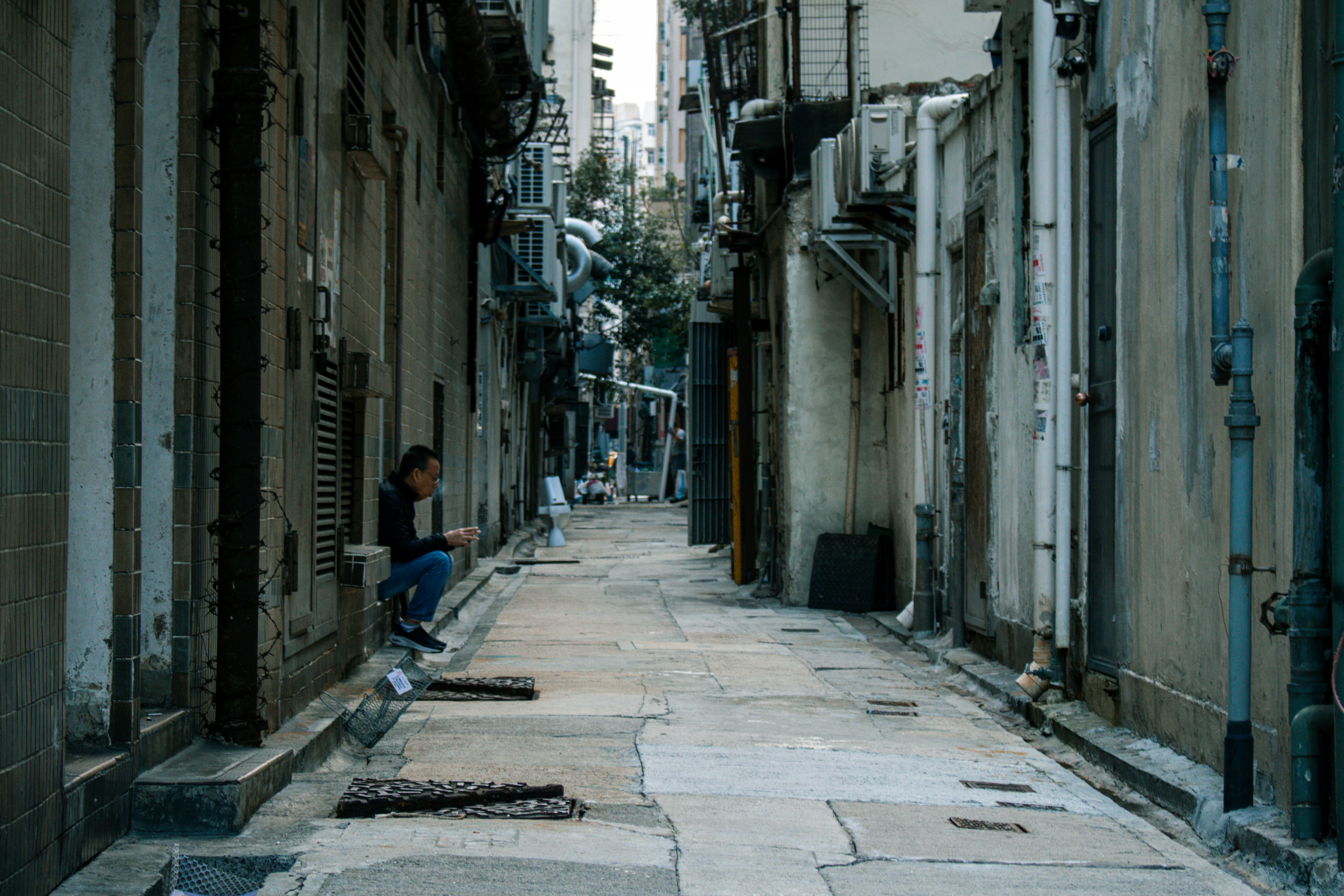 Quiet Alley Confinement: A Stranger Sits in the Shadowed Wall