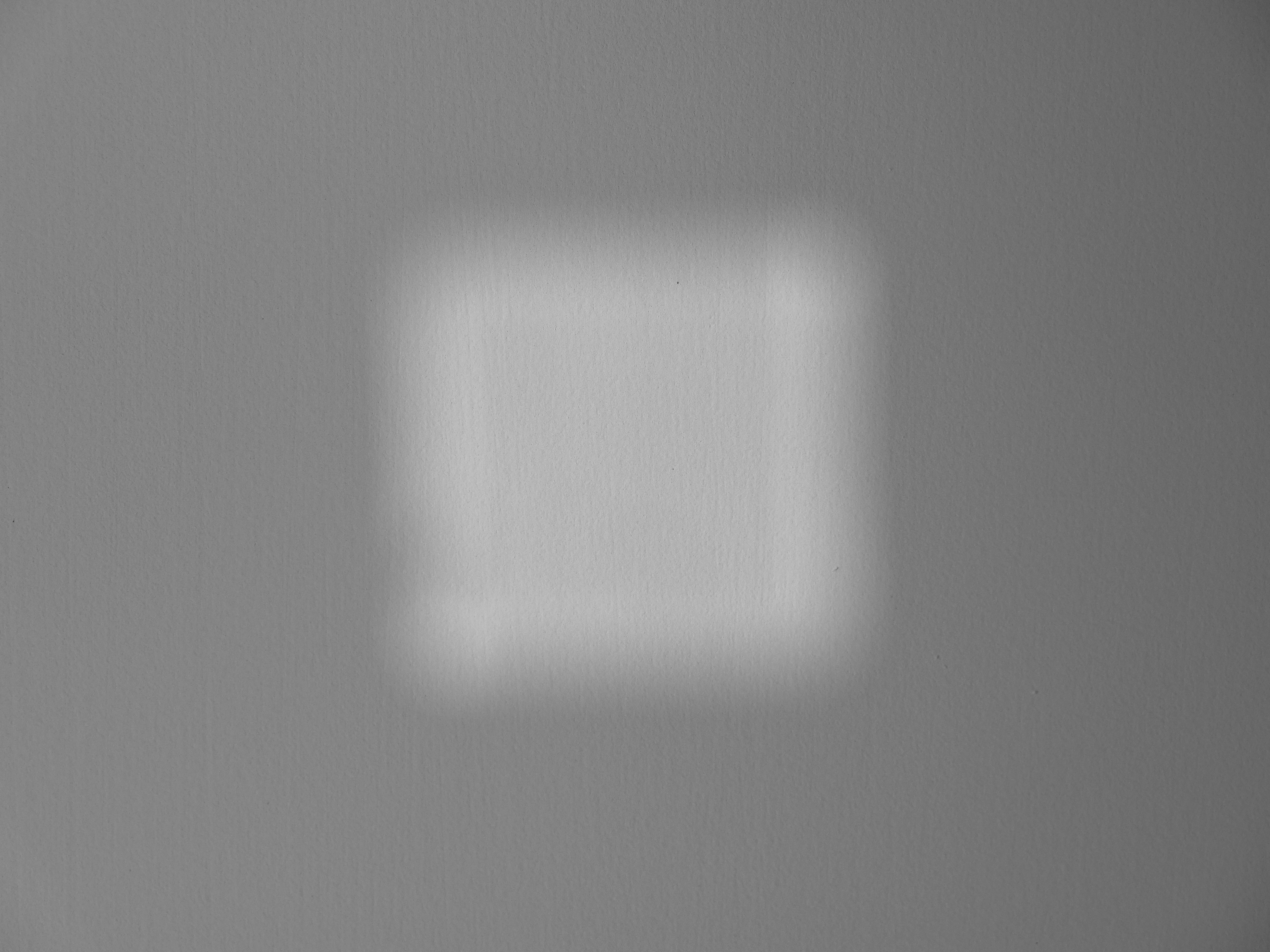 Soft Spotlight on a Central Square: Subtle Texture in a Monochrome Space