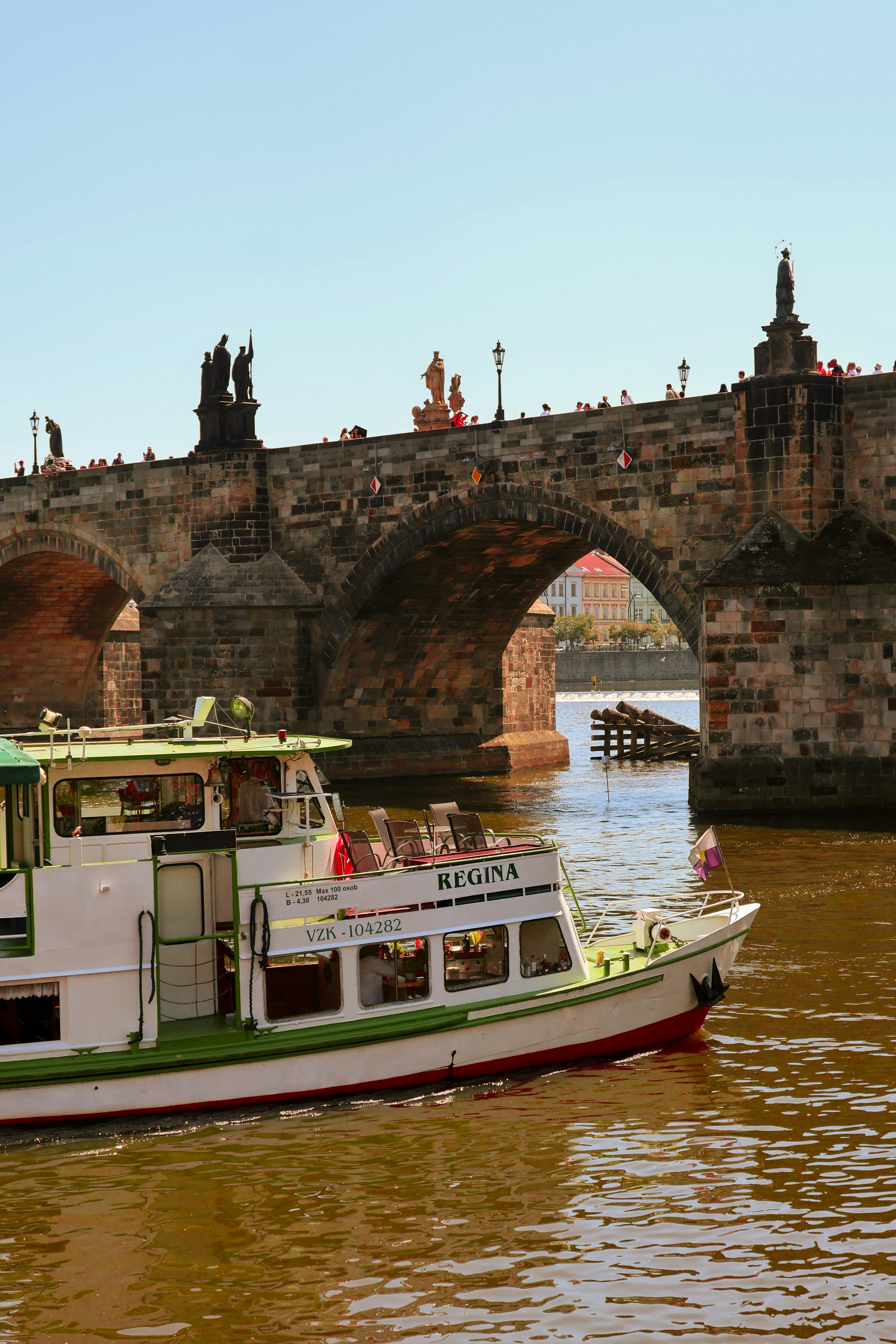 Bridge and Boat in Prague: A Sunlit River Scene