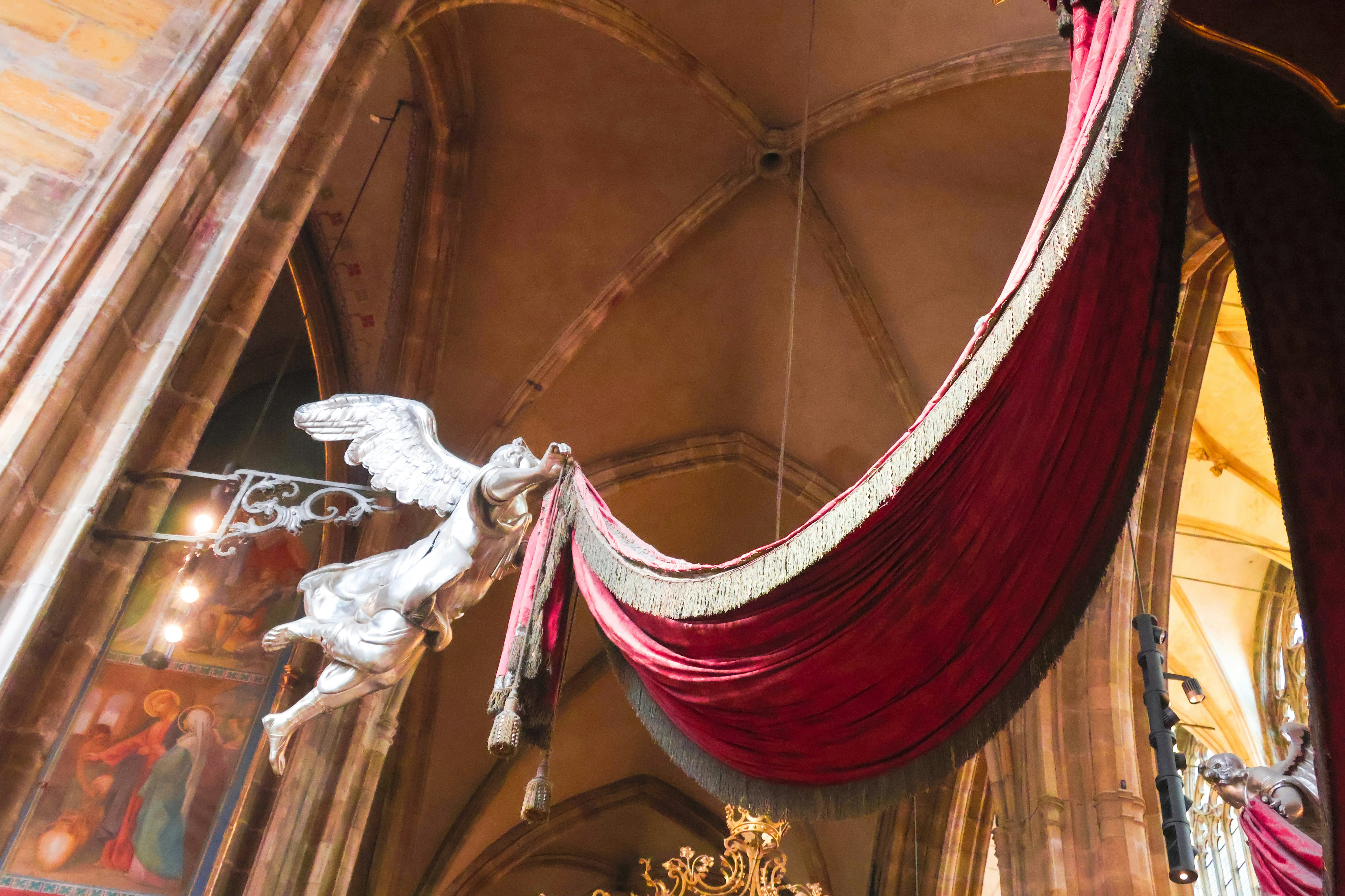 Crimson Drapery SuspendedAbove Aisle with Angelic Sculptures