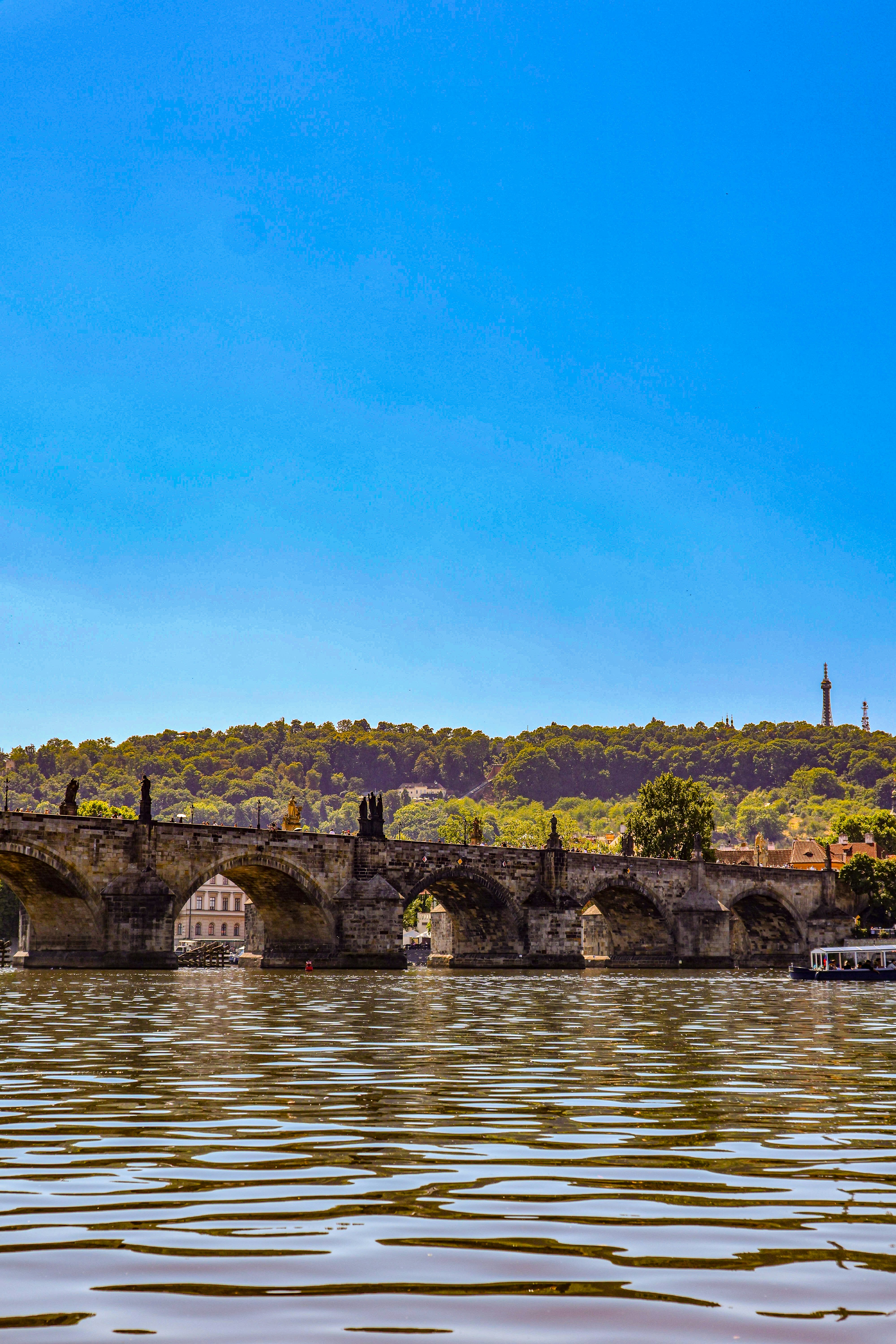 Stone Arches Over a Serene River Under a Clear Summer Sky