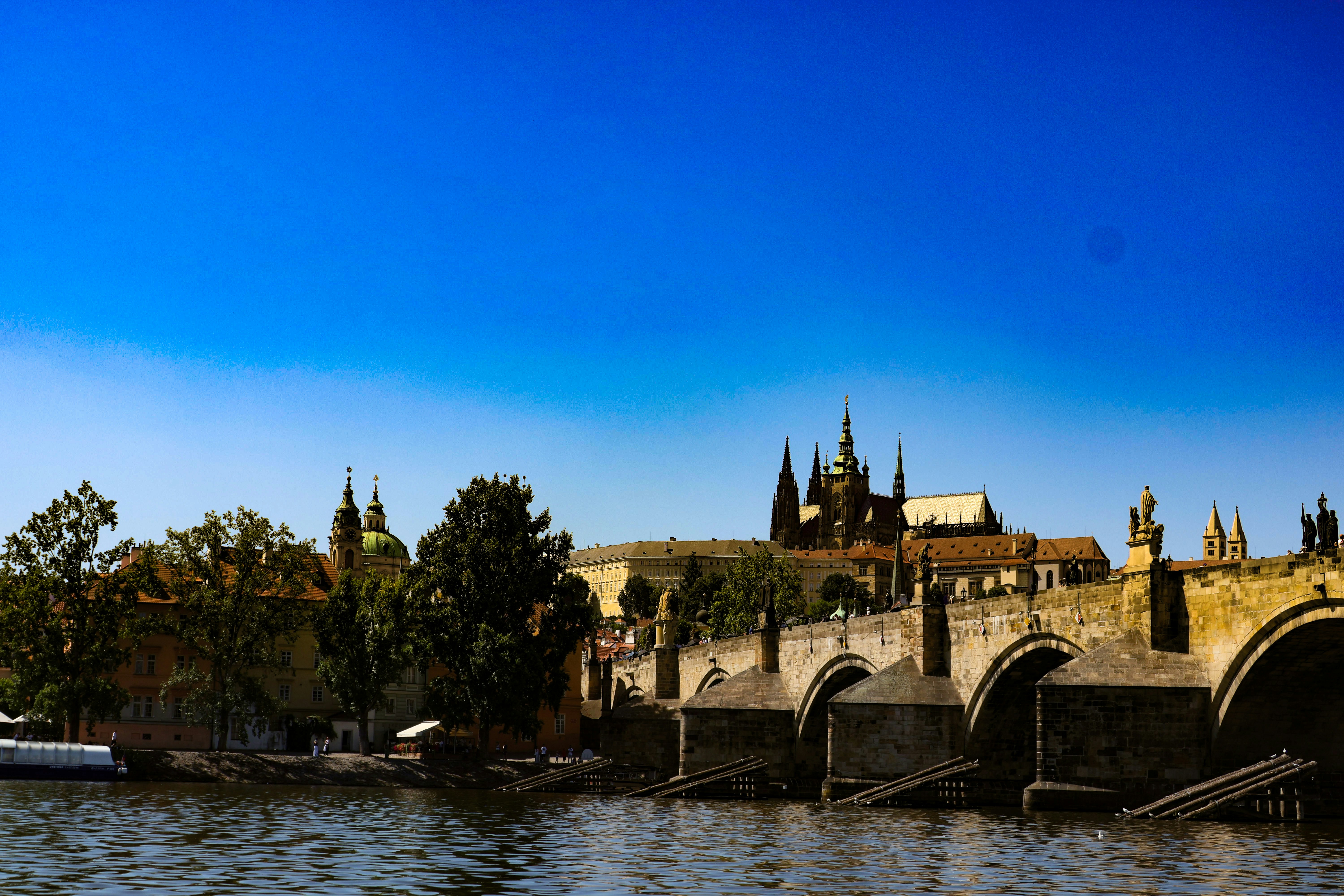 Sunlit Stone Bridges and Riverbank: A Historic Cityscape
