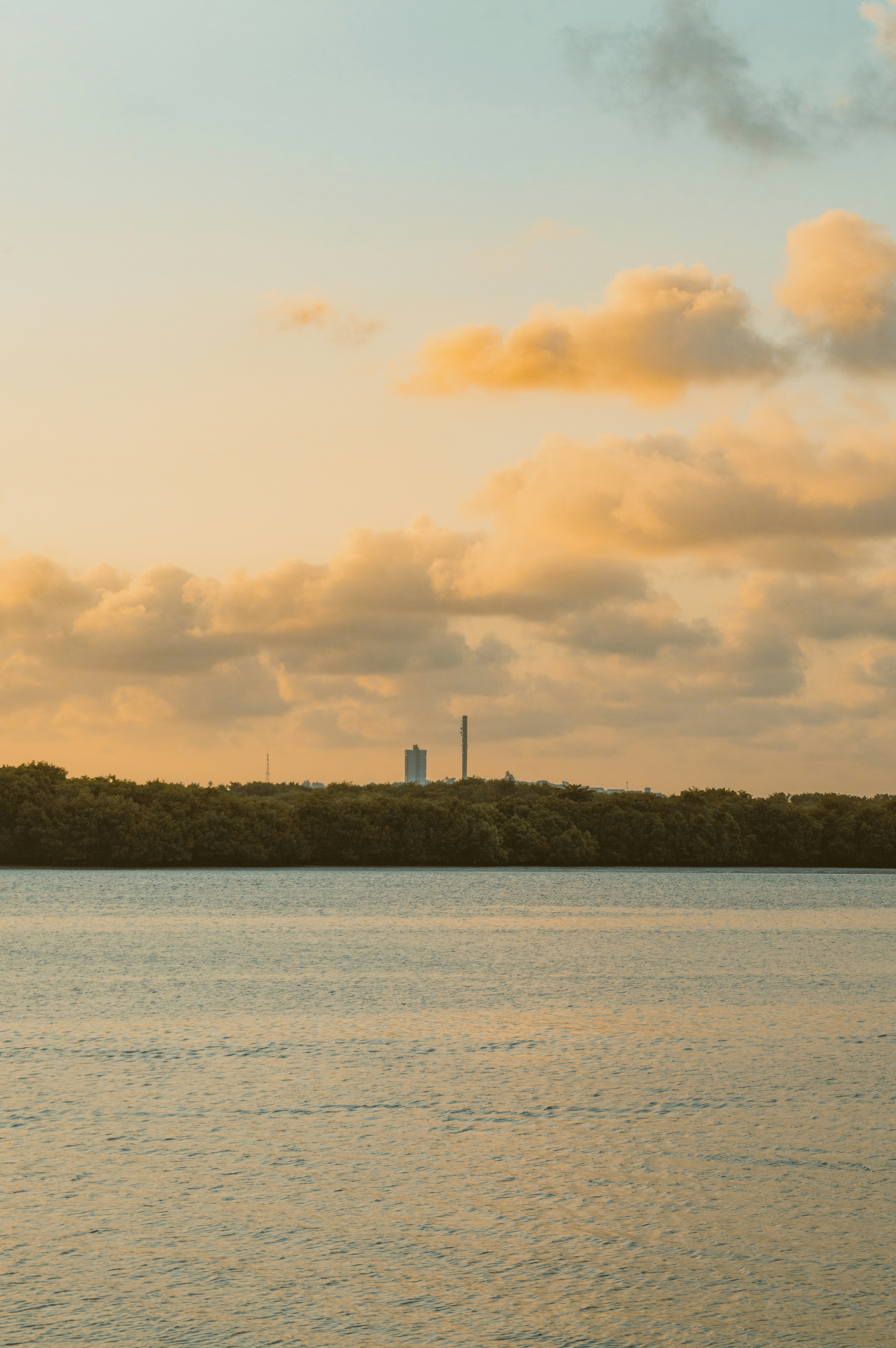 Sunset Over Quiet Water with Distant Industrial Silhouette