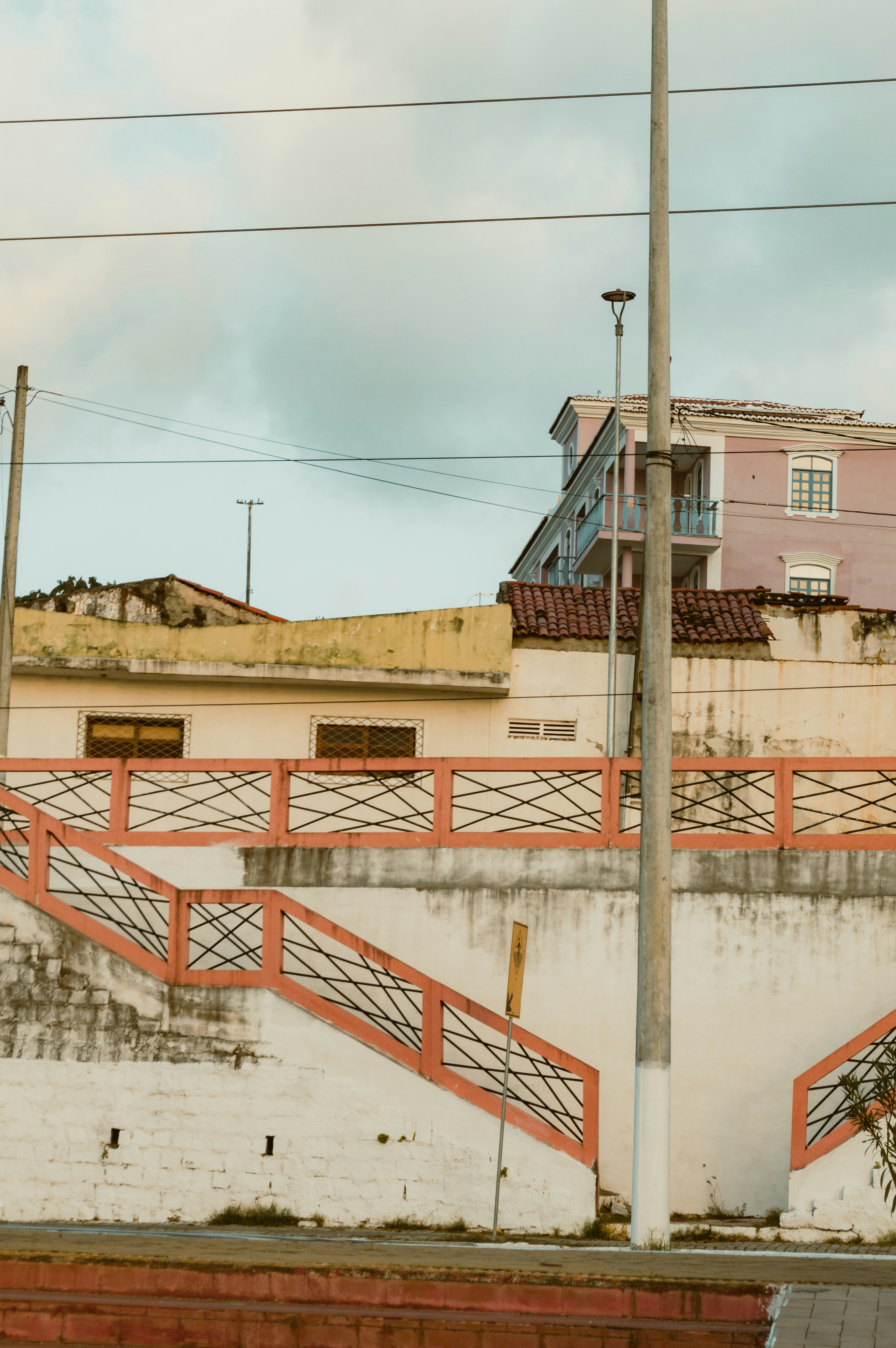 Urban Geometry: Peach-pink Facade Behind a Sturdy Stair Rail