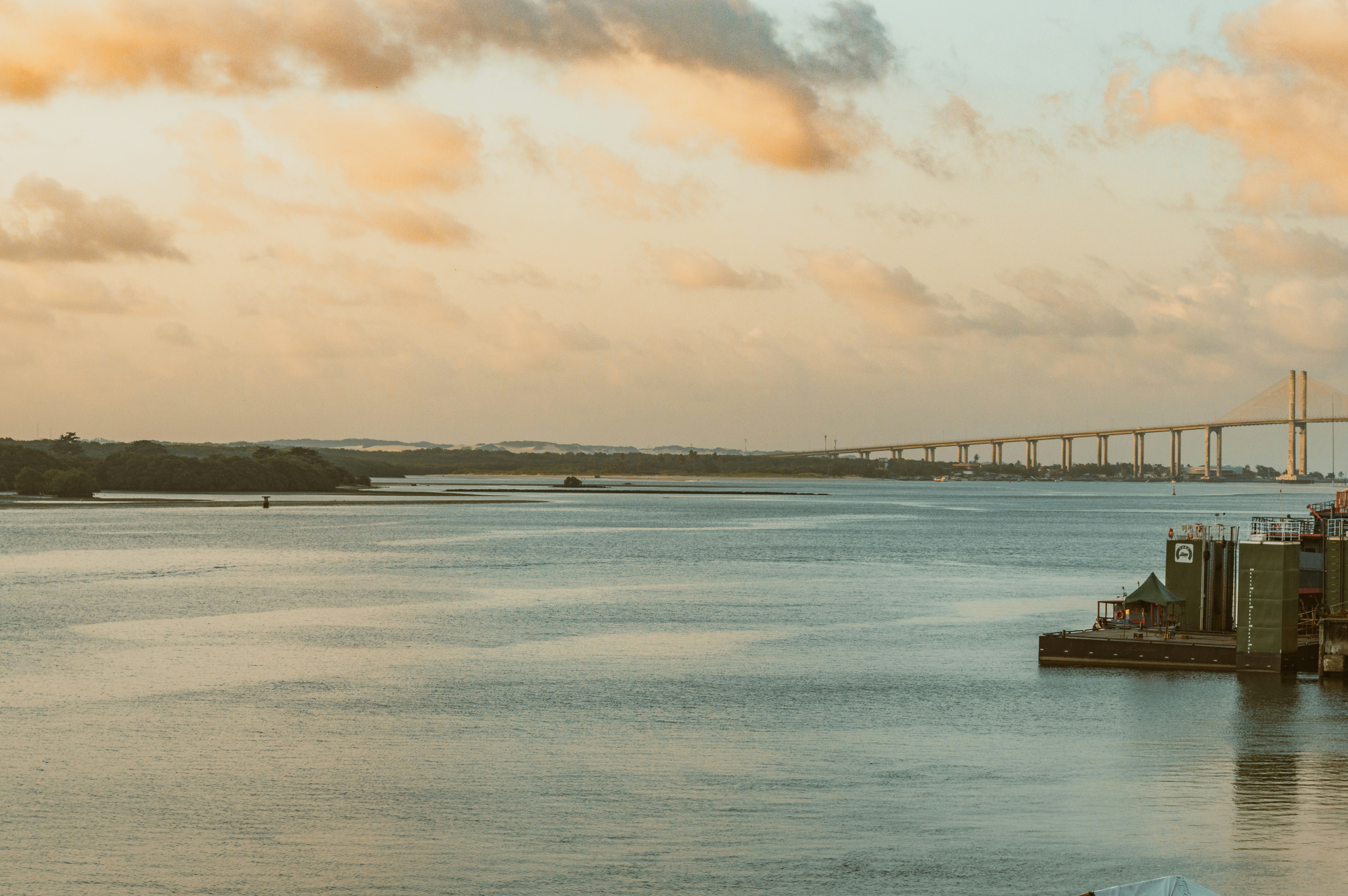 Sunlit Estuary: A Quiet Distant Bridge Over Calm Waters