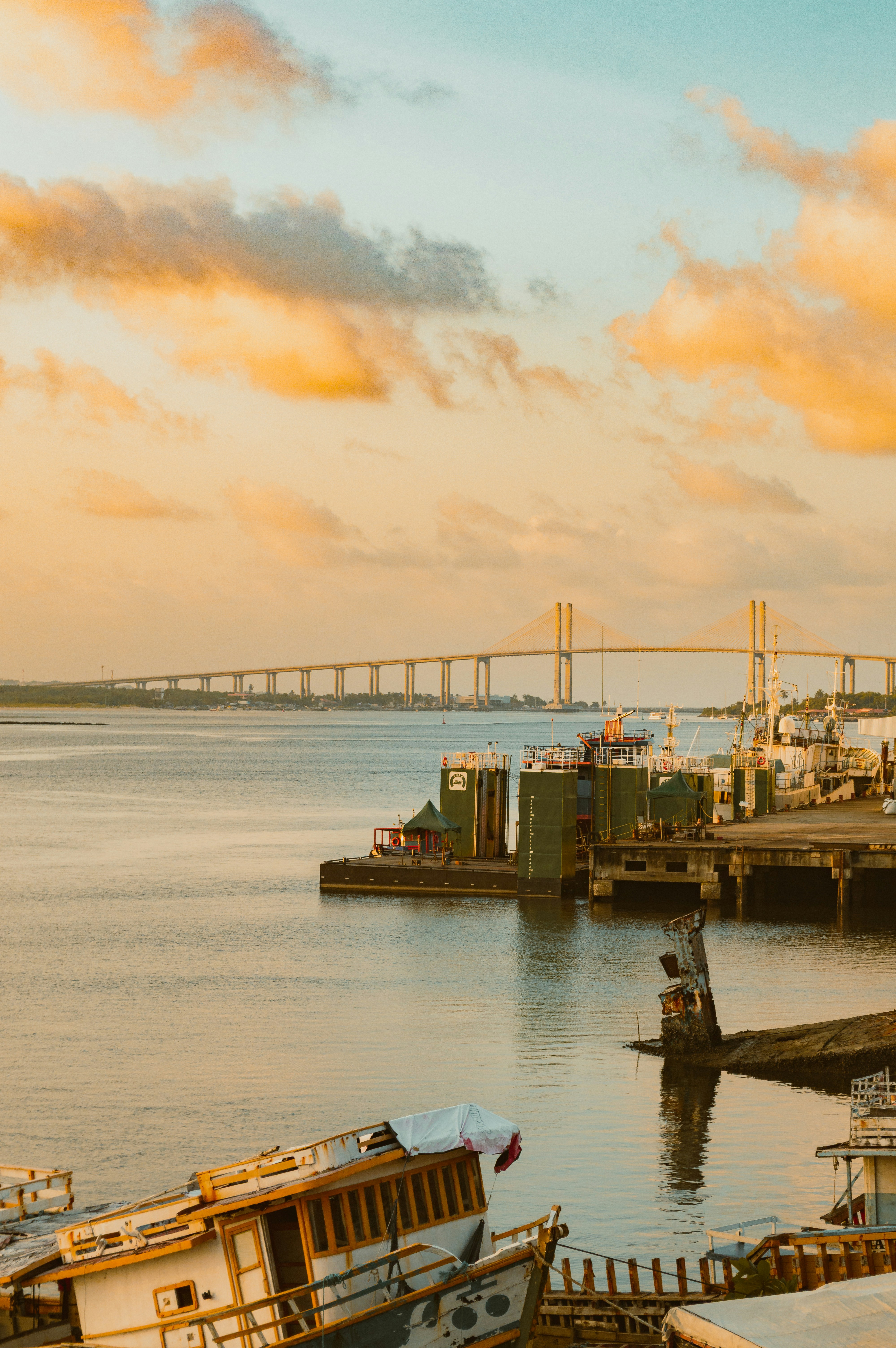 Harbor Twilight: Boats Rest along a Quiet Distant Pier Under a Golden Sky