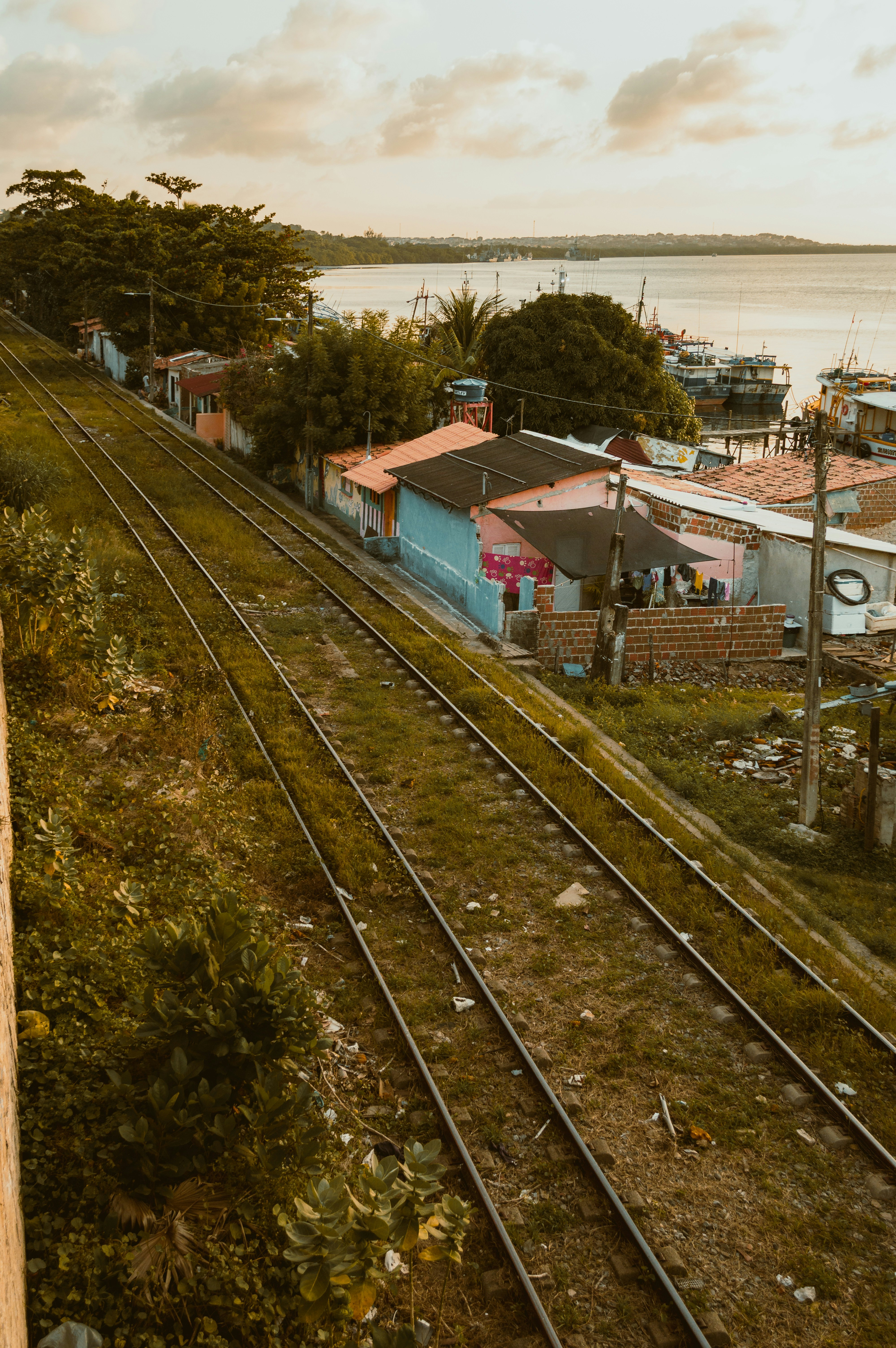 Rusted Rails and Colorful Cliffs: A Riverside Settlement below the Sunset