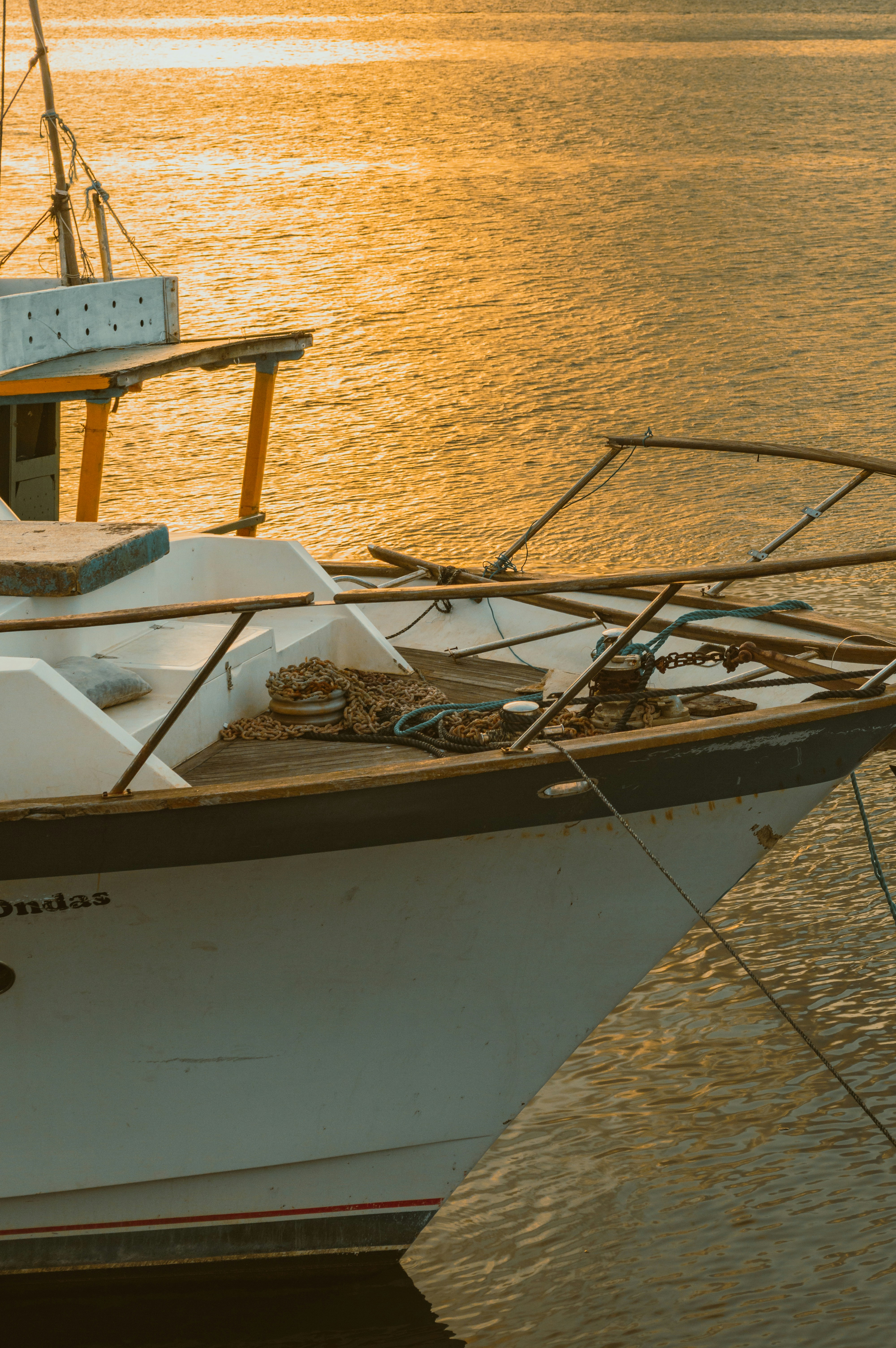 Sunlit Bow: A Quiet Vessel Resting on Golden Water