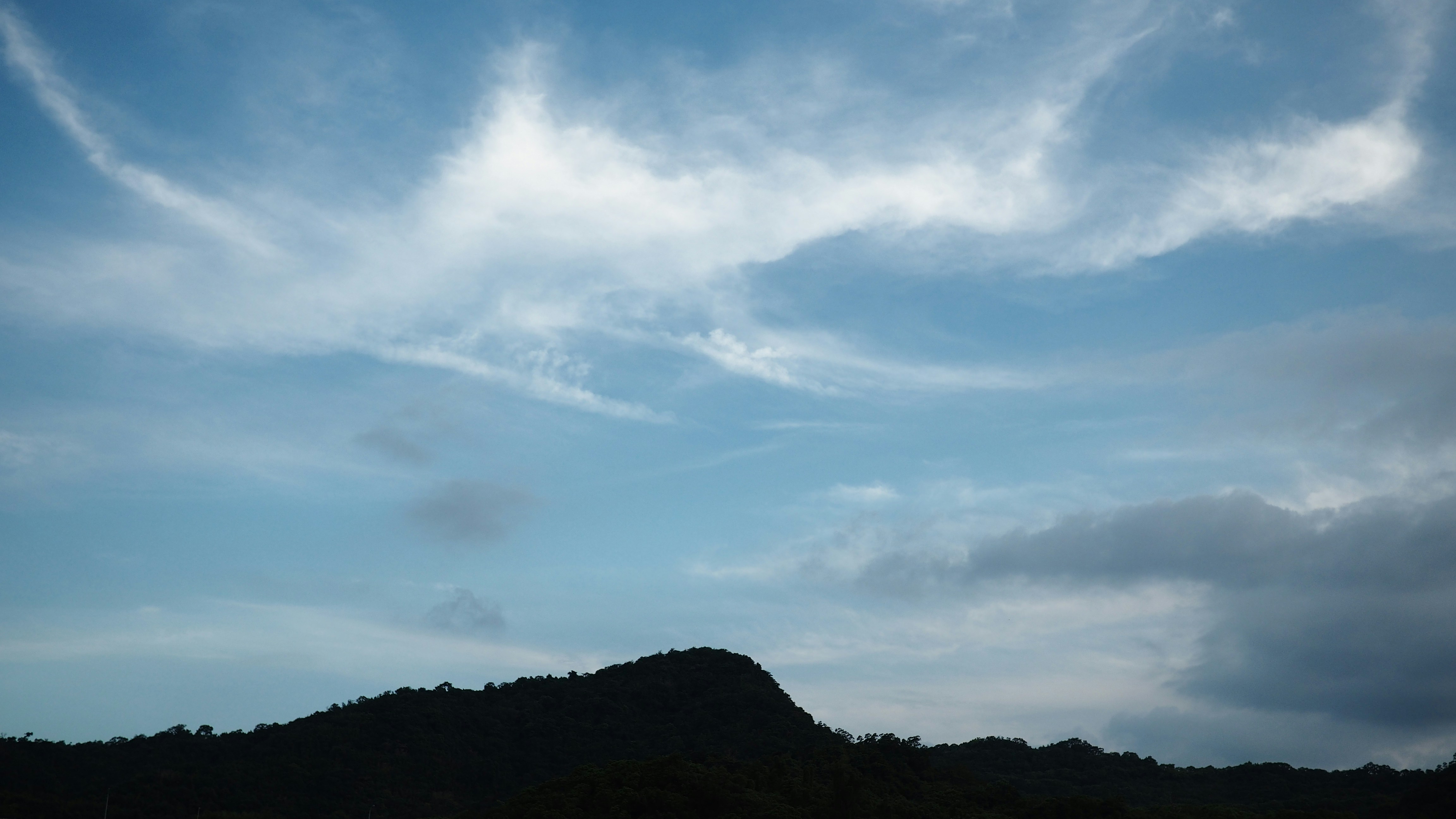 Horizon Crown: The Quiet Peak Beneath a Wisp of Sky