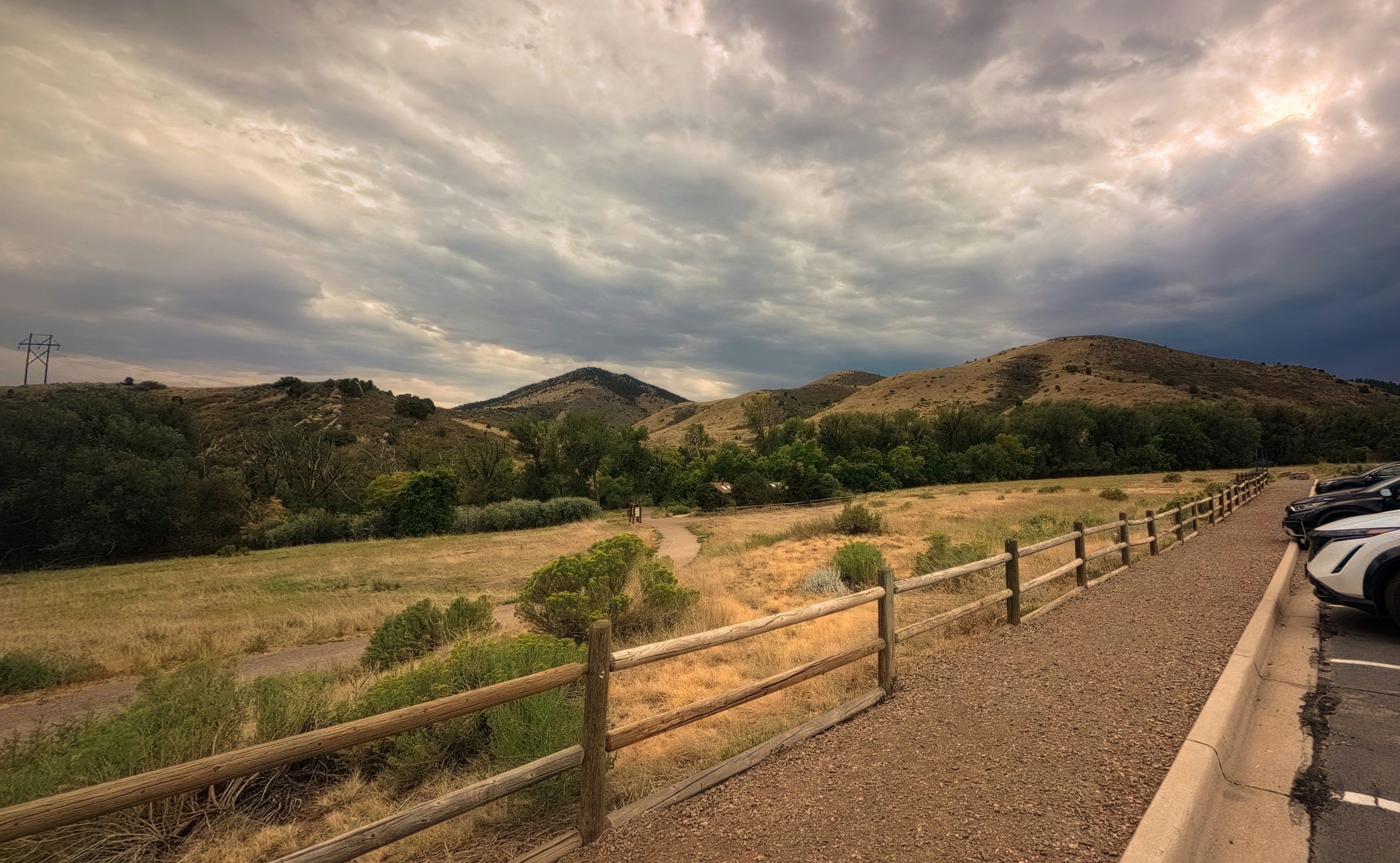 Ridge Vista: A Quiet Sunset Over Rolling Hills and Fenced Path