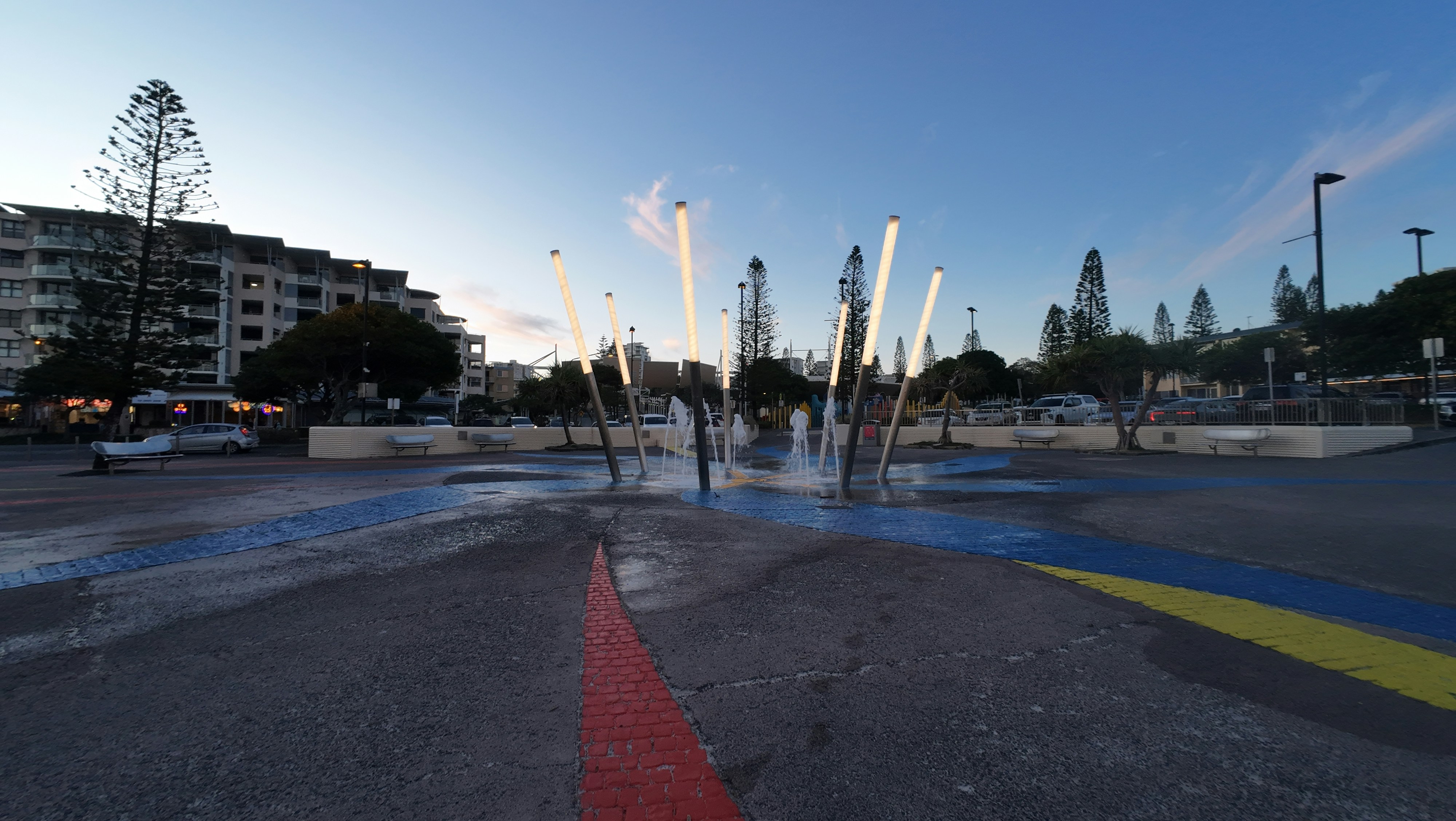 Rising Light Columns in a Public Square at Dusk