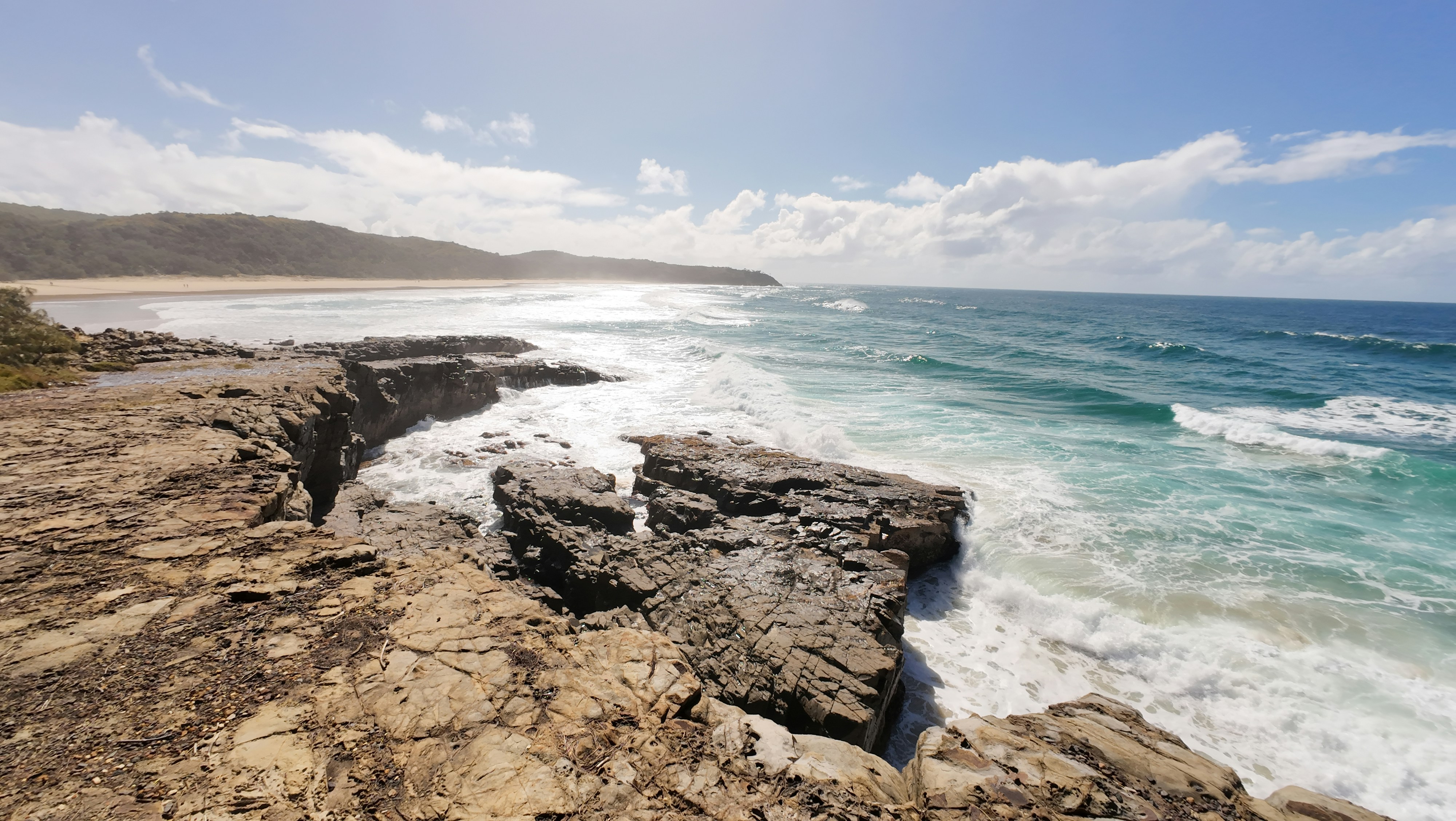 Cliffline Confluence: Sunlit Rock Formations Meet Atlantic Swell