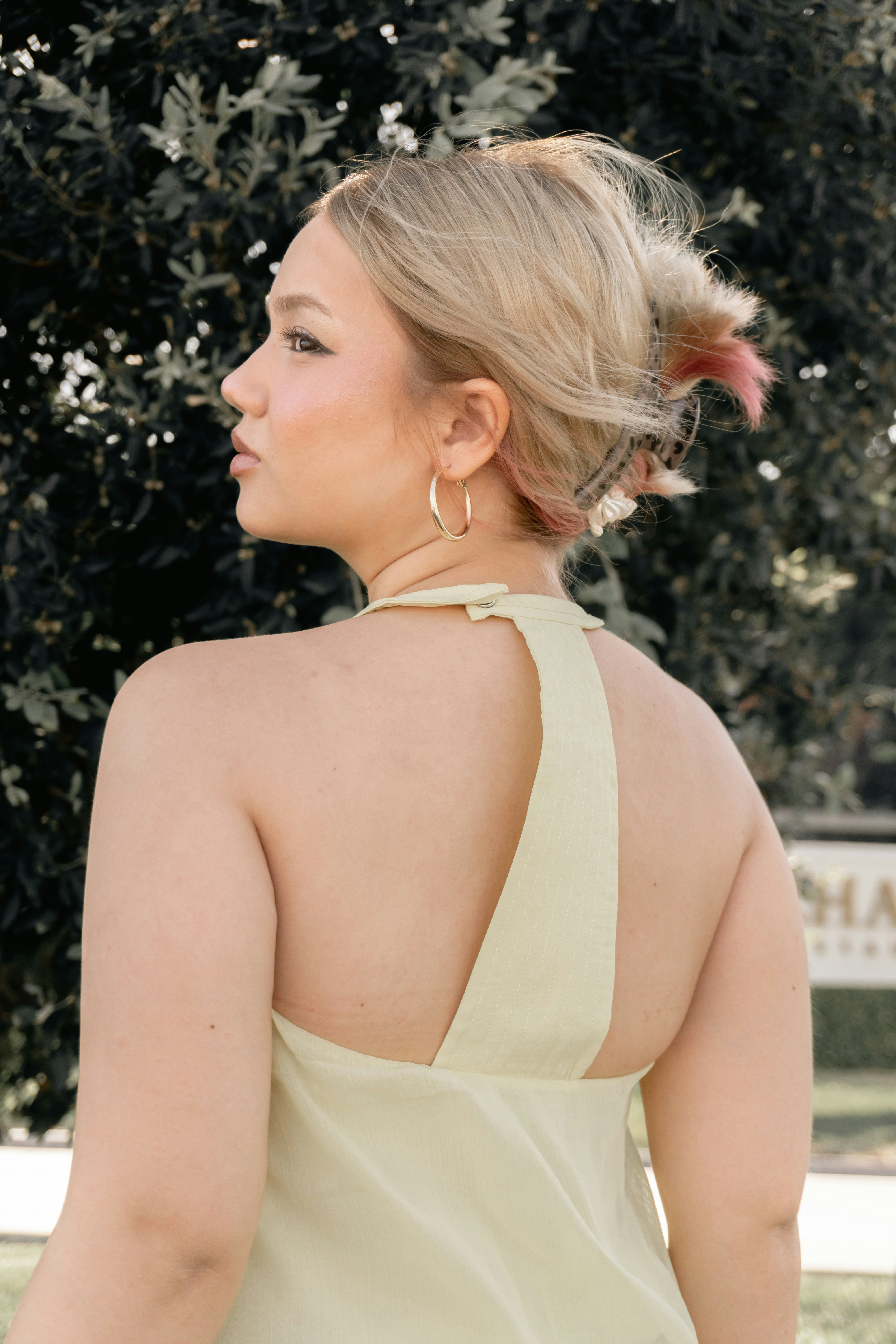 Backlit Grace: Portrait of a woman in pale halter seen from the shoulder