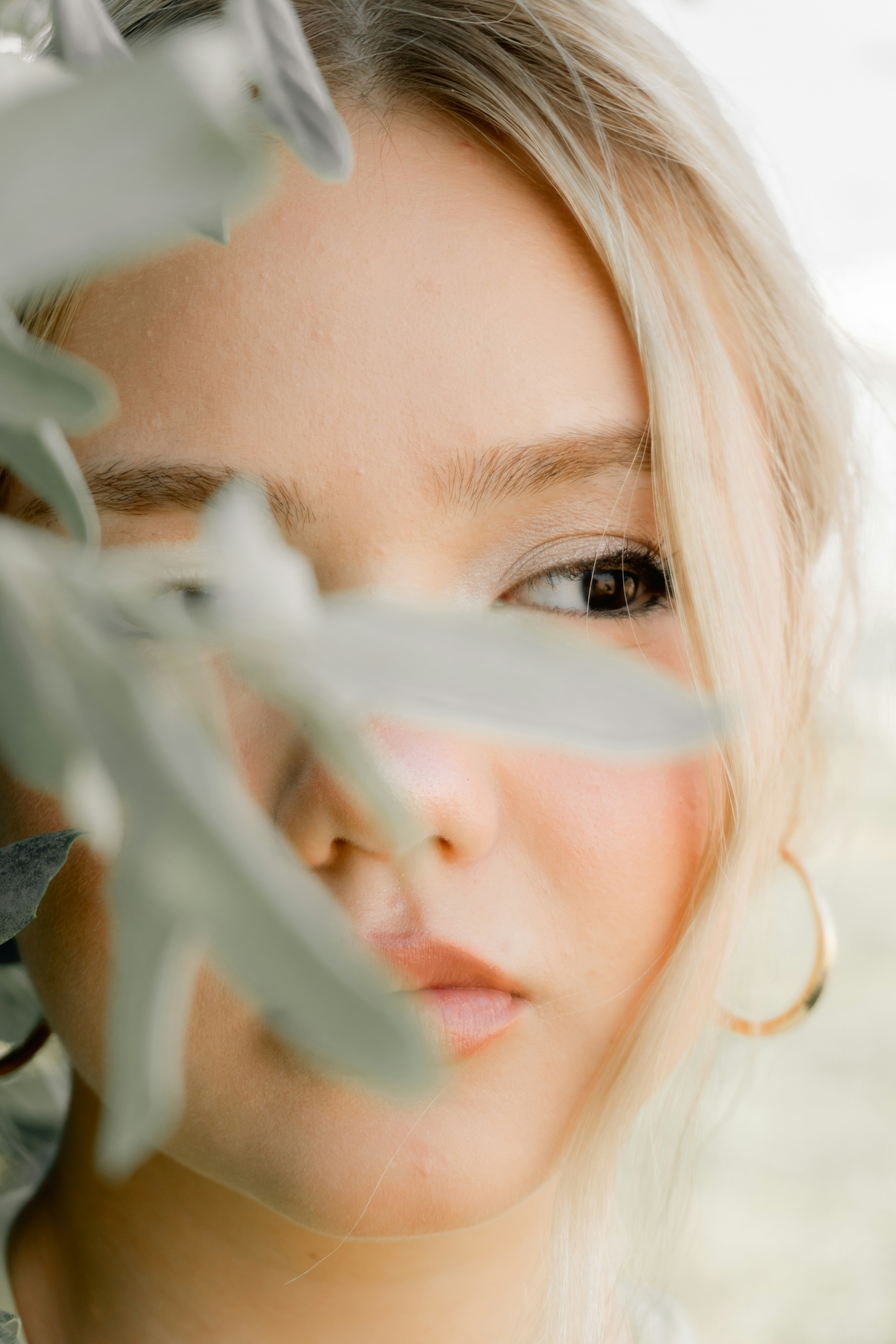 Soft Focus Portrait Through Foliage: A Gaze Beyond the Leaves