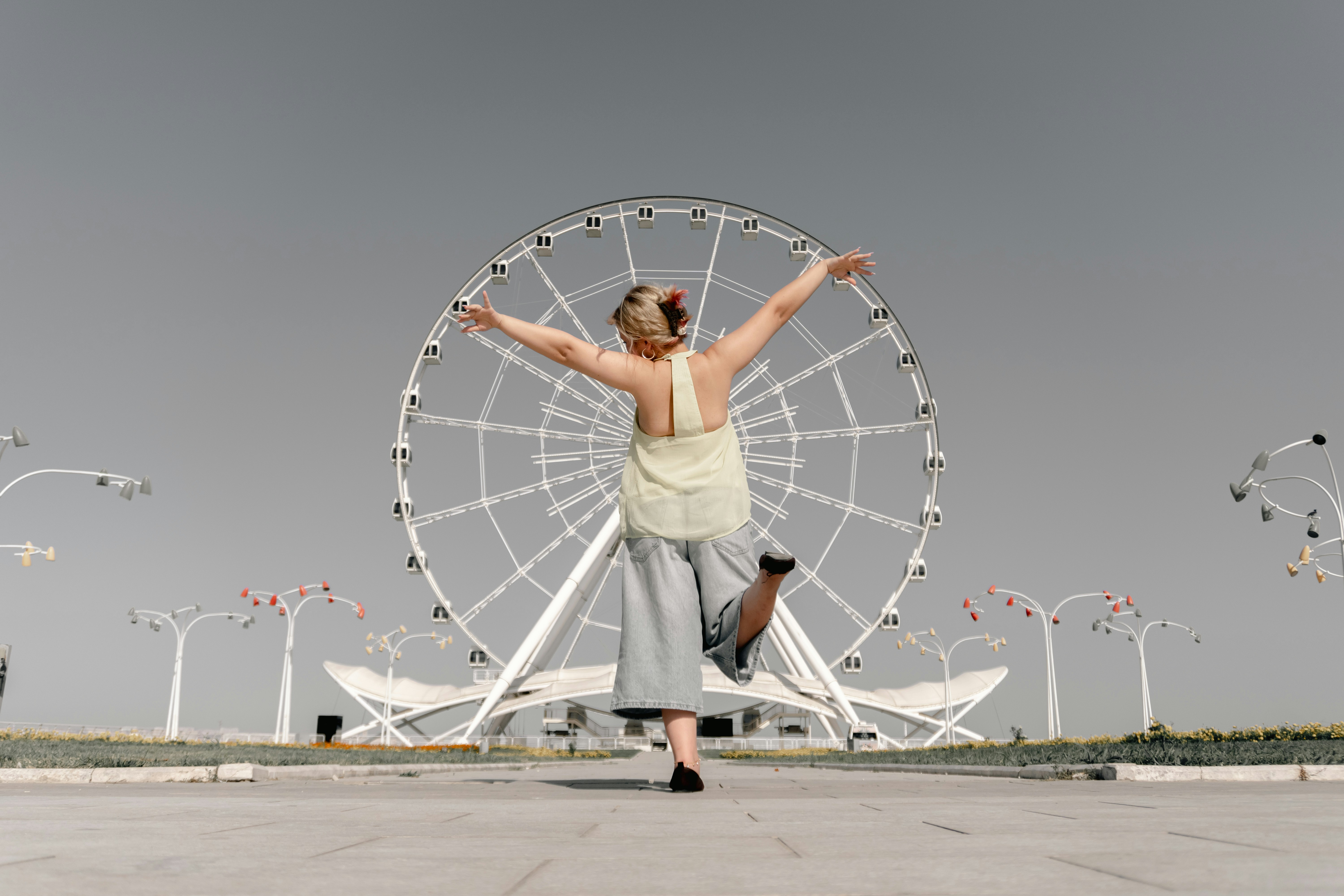 Joyful Leap in Front of a Giant Ferris Wheel