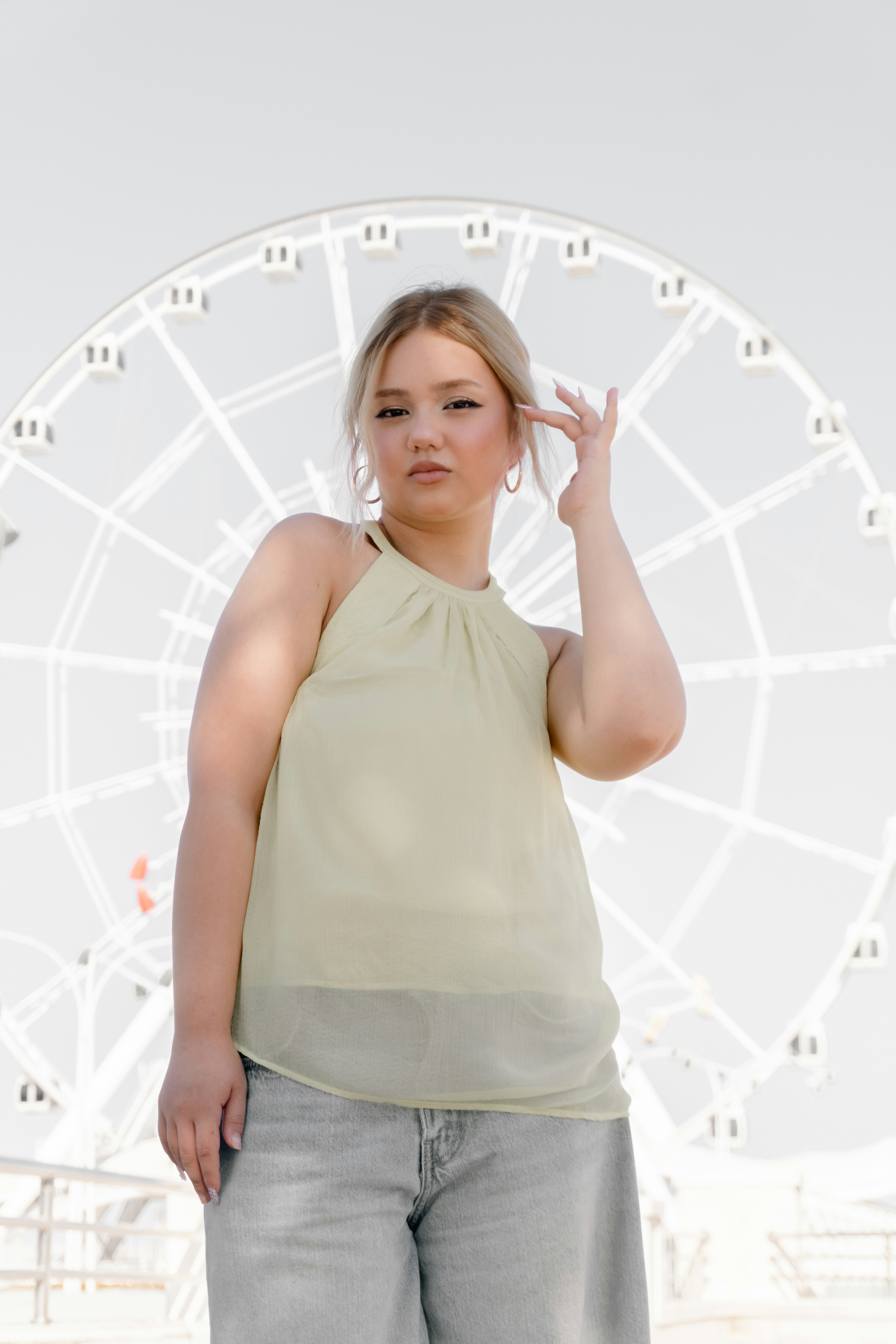 Portrait under a Ferris Wheel: confident stance and sunlit silhouette