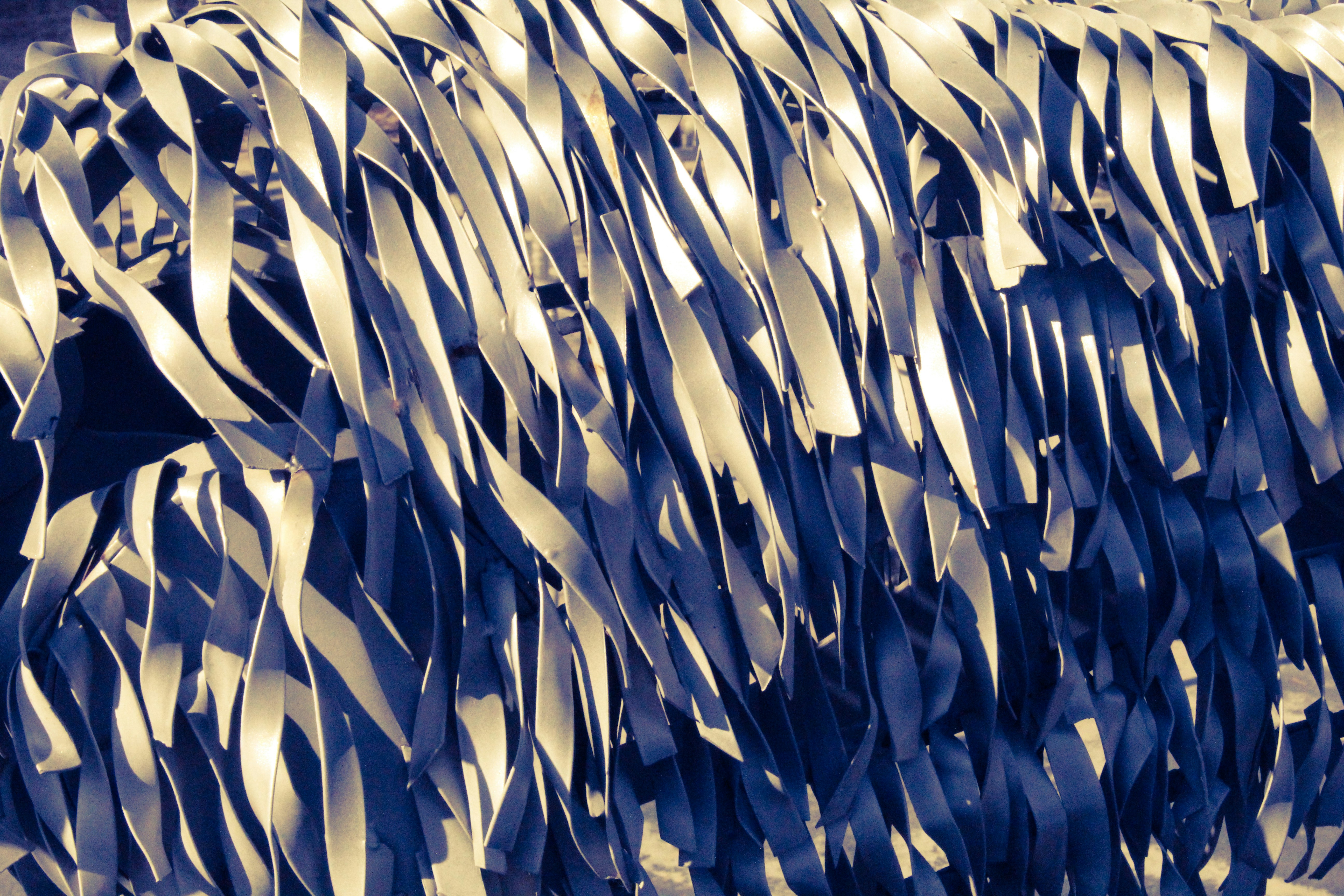 Cascade of metallic ribbons in motion against a dusky backdrop