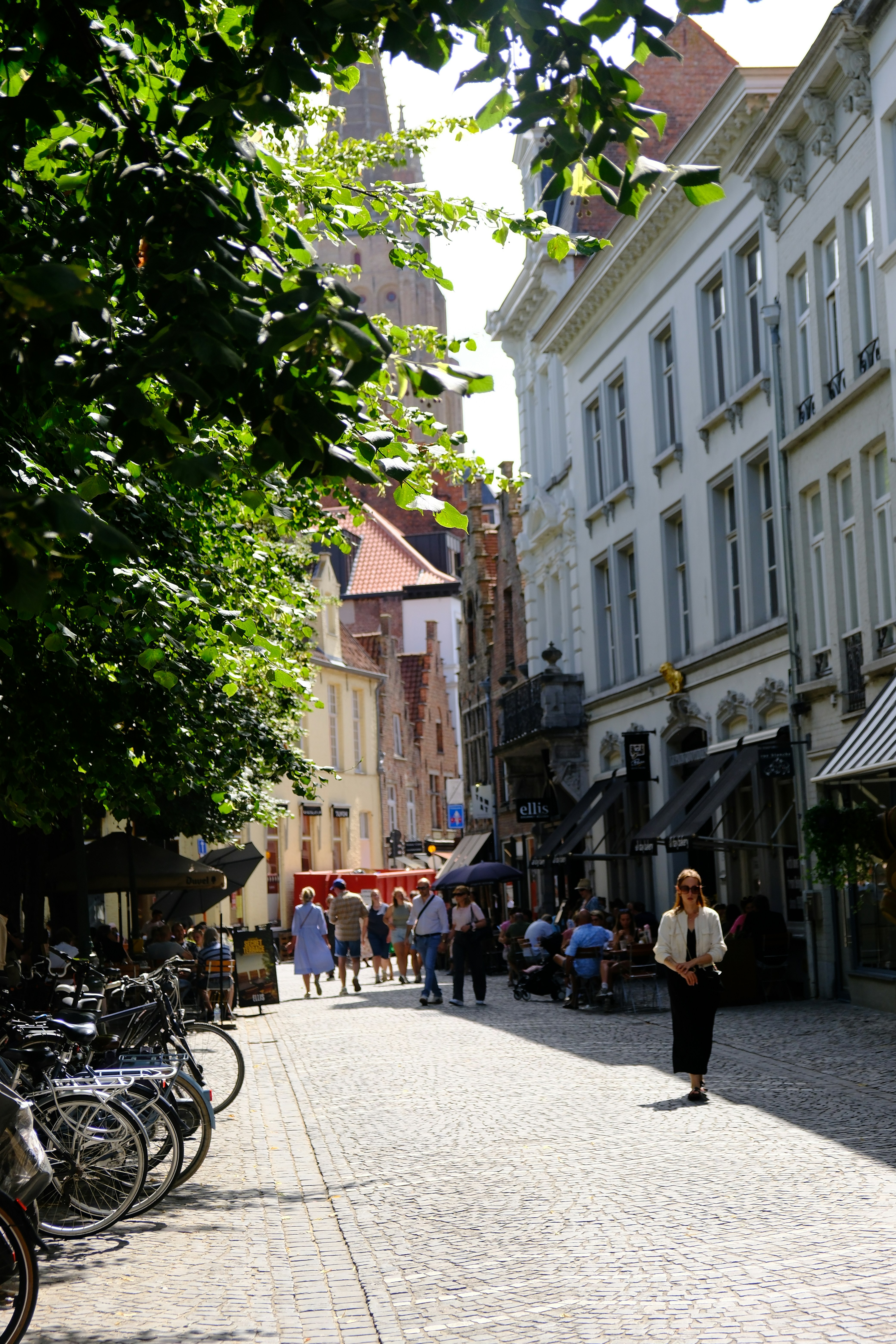 Cobbled Street Café Corridor Framed by Sunlit Facades
