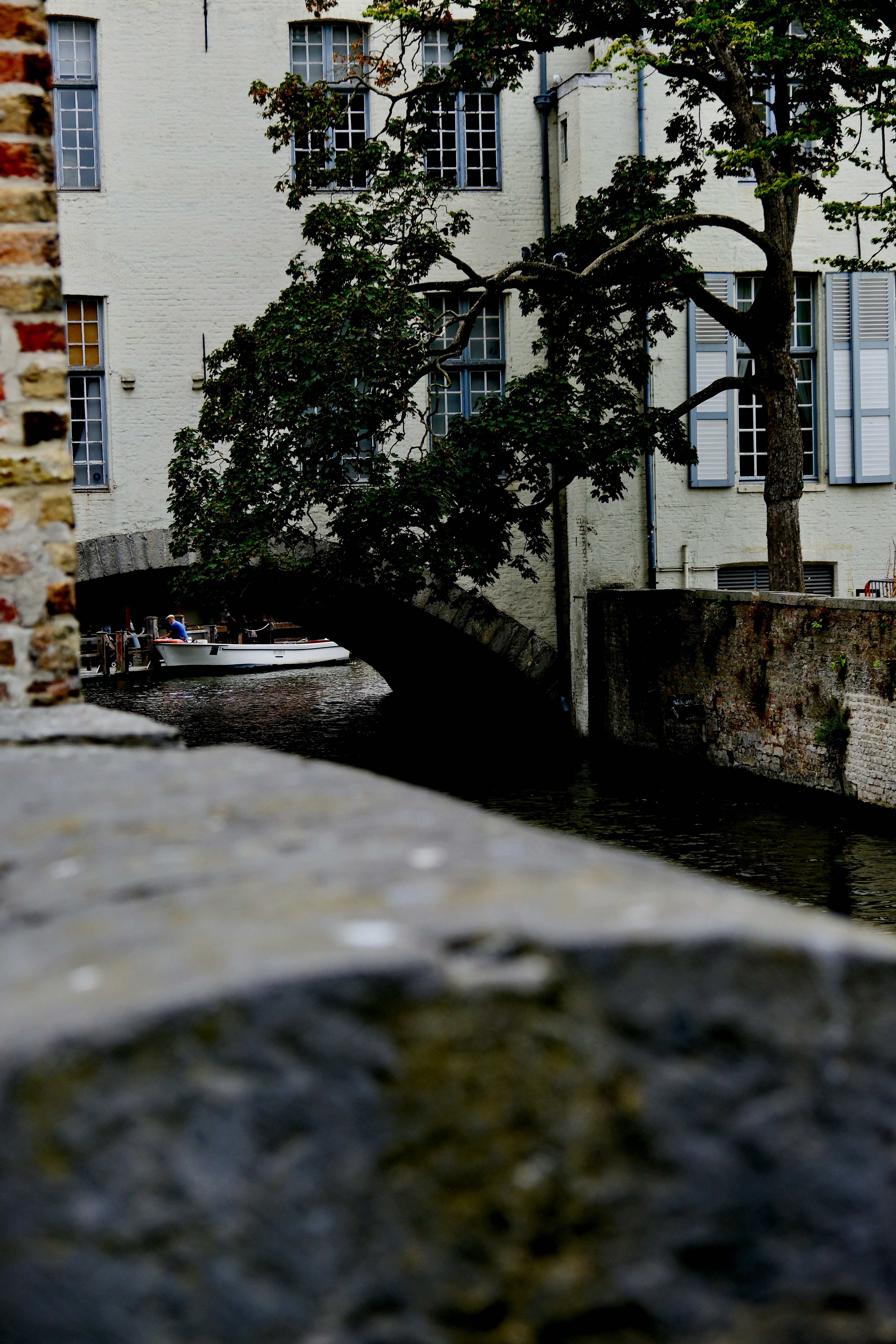 Hidden Watery Alley: Boat and Bridge Reflections in a Calm Canal