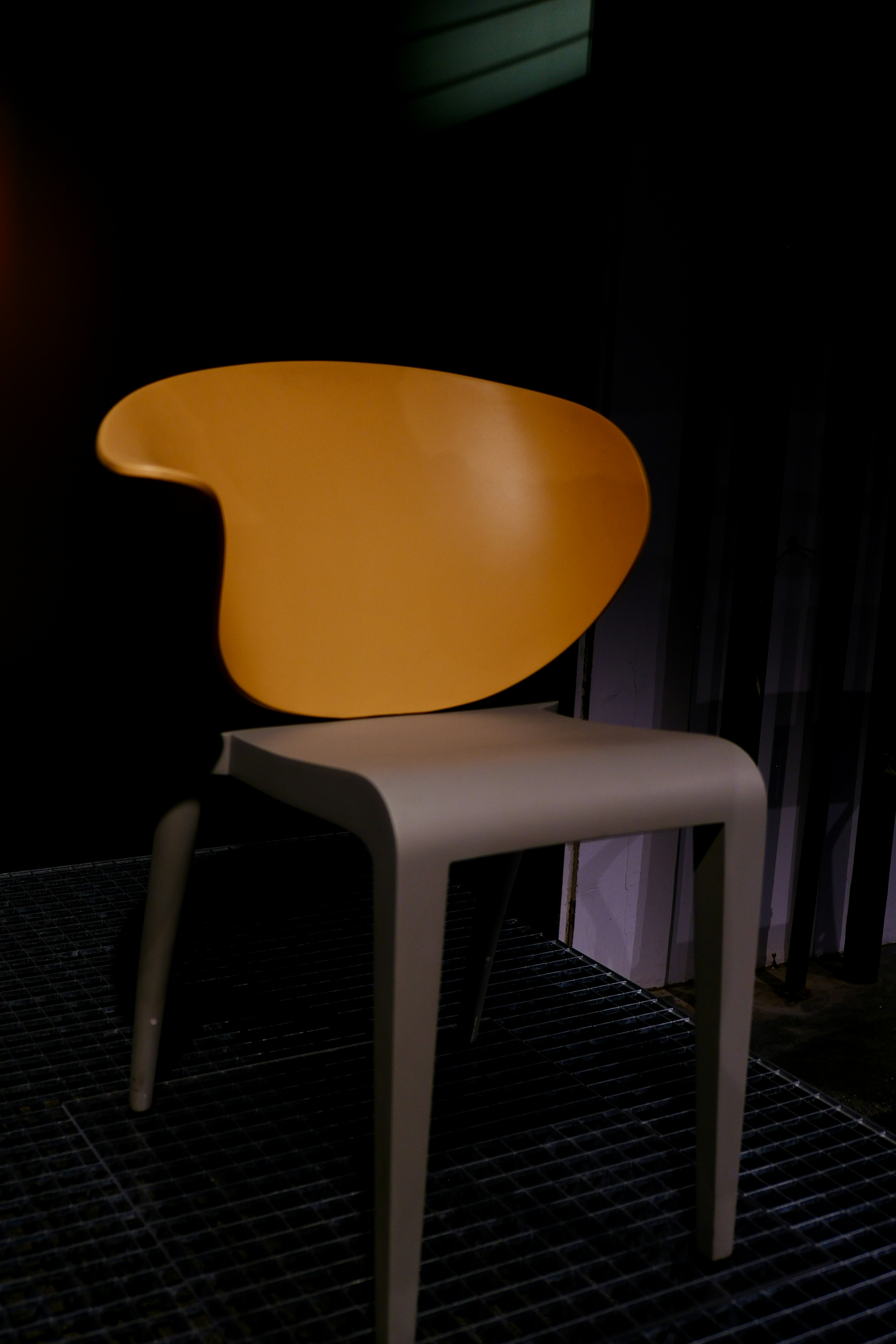 Solitary Amber Shell: A Modern Chair in Dim Light