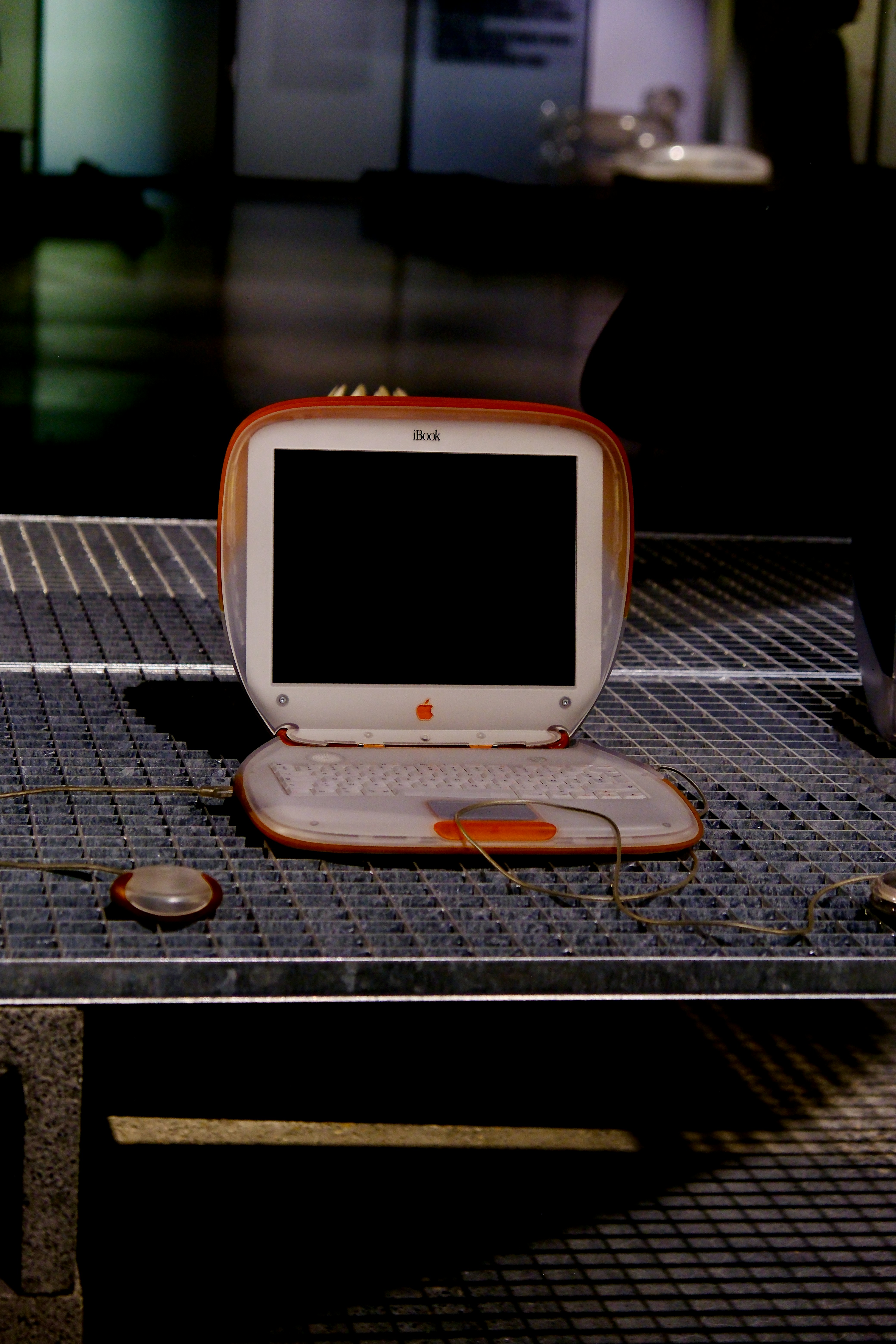 Retro mini computer on a metal grate with orange case and white keyboard