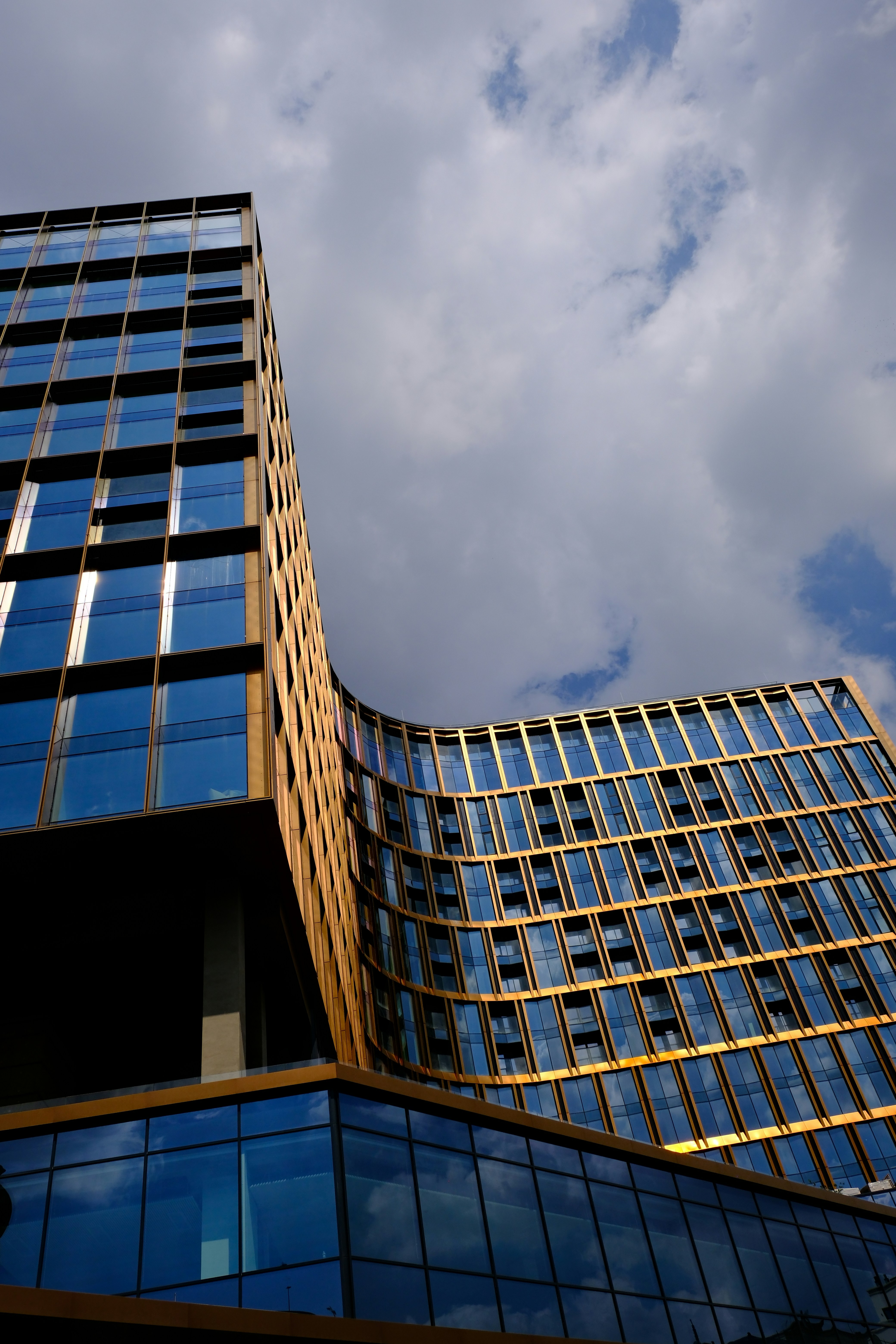 Architectural Wave: The Golden Framed Curve of Glass and Sky