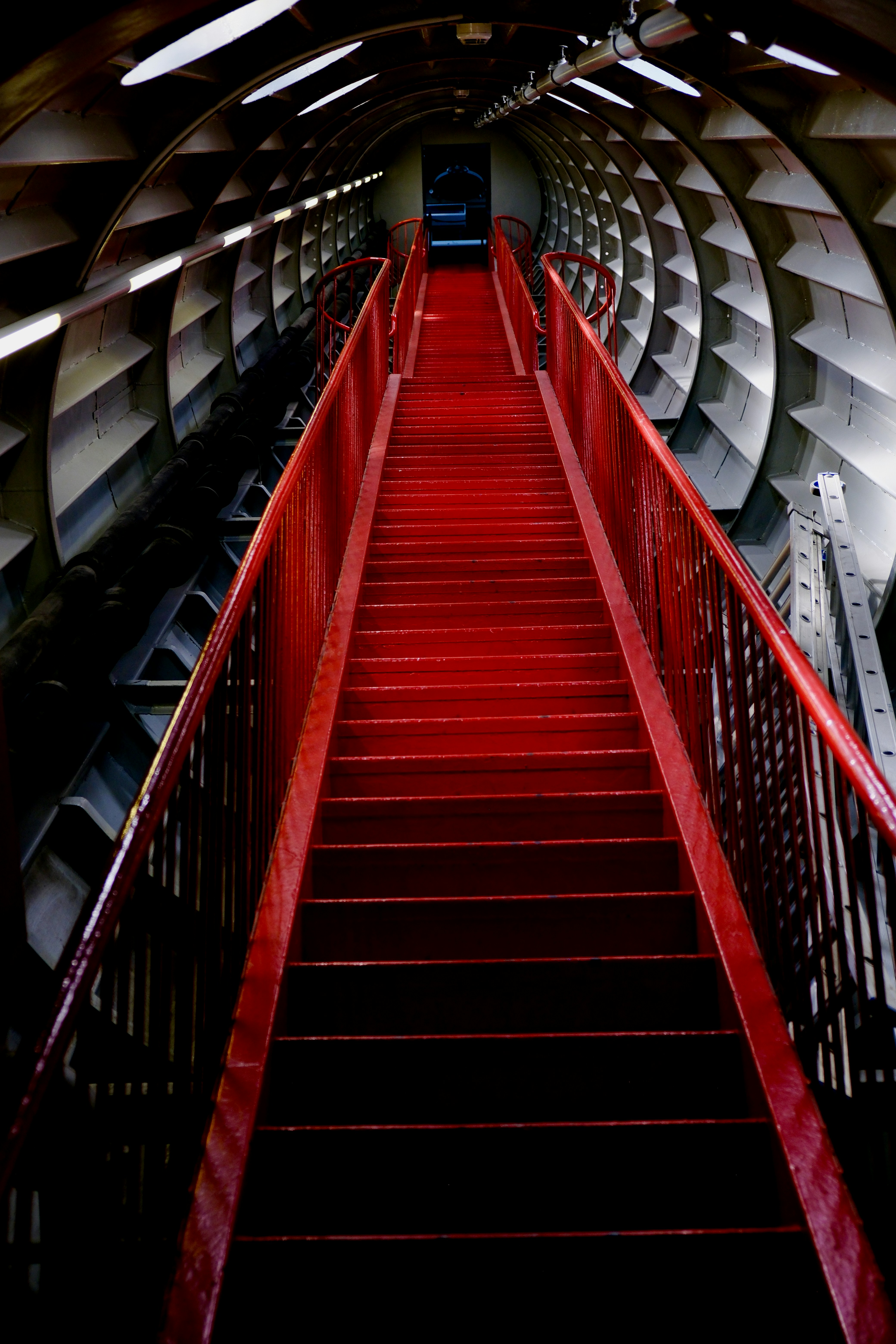 Red Staircase Through a Metallic Tunnel