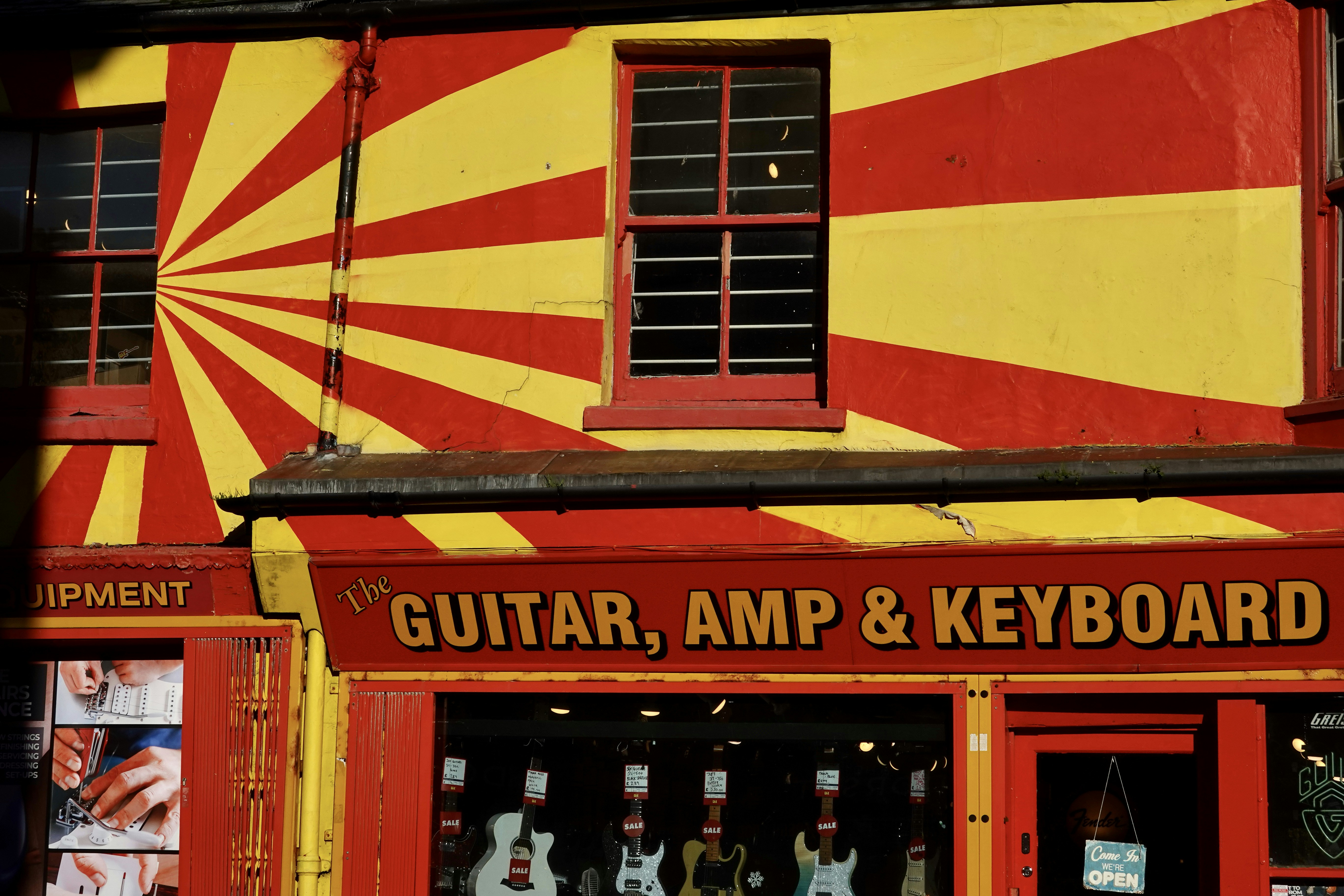 Sunburst Shopfront: Electric Red and Yellow Guitar Haven